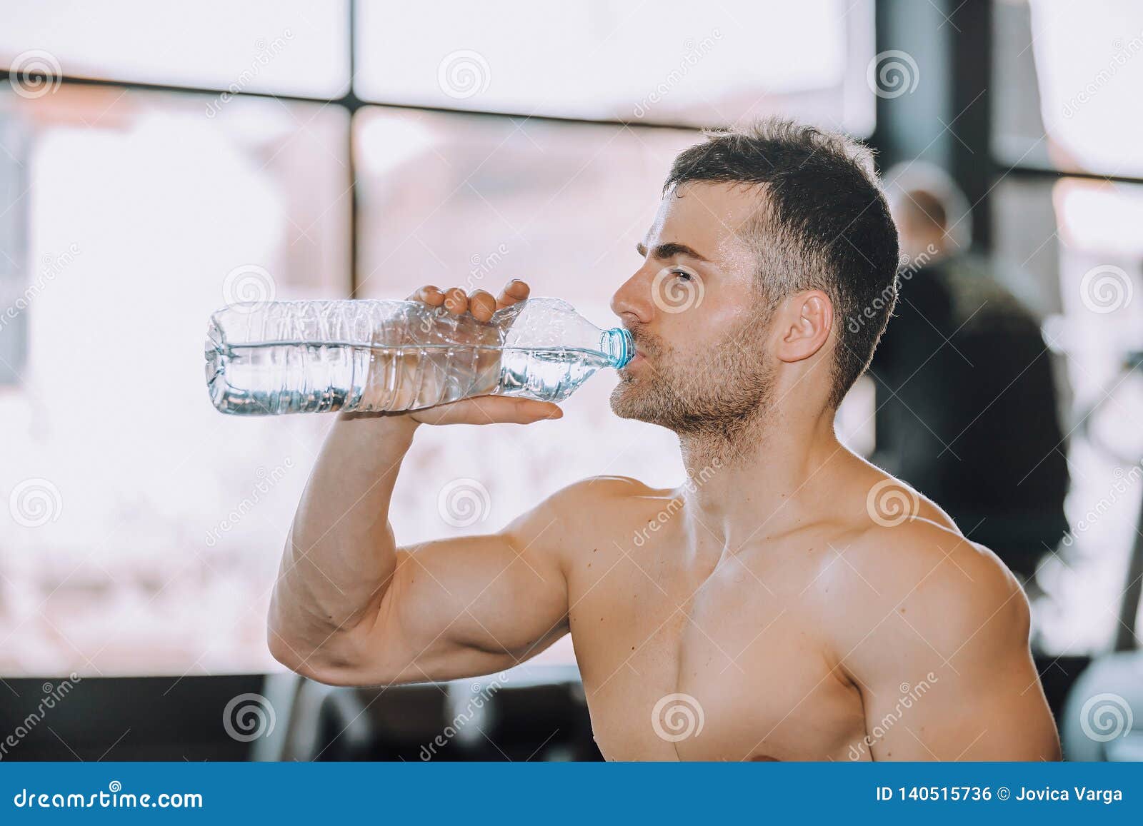 Handsome Young Man Drinking Water from a Bottle in a Gym Stock Photo ... Handsome Young Man Drinking Water from a Bottle in a Gym Stock Photo ...