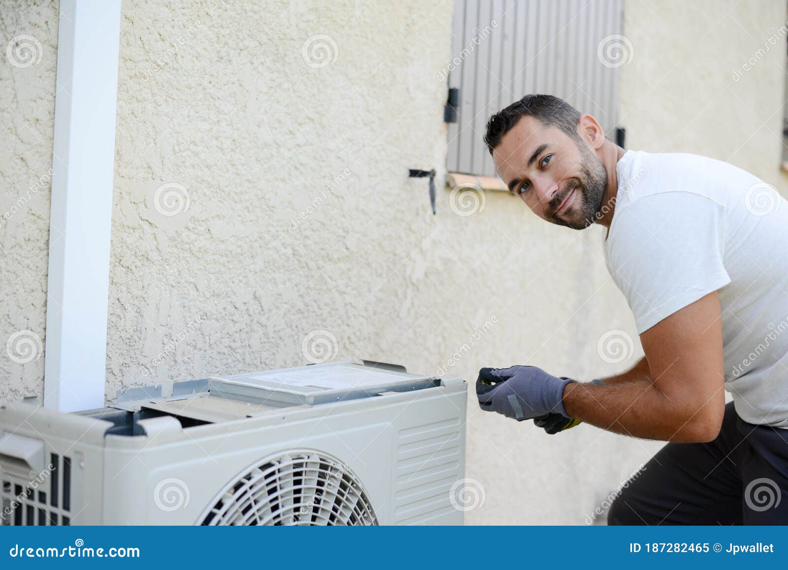 Handsome Young Man Electrician Installing Air Conditioning in a Client ...