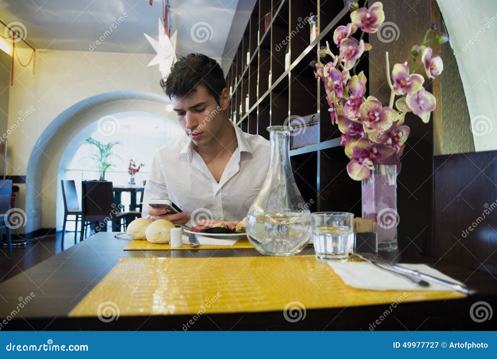 Handsome Young Man in Elegant Restaurant Using Cell Phone Stock Image ...