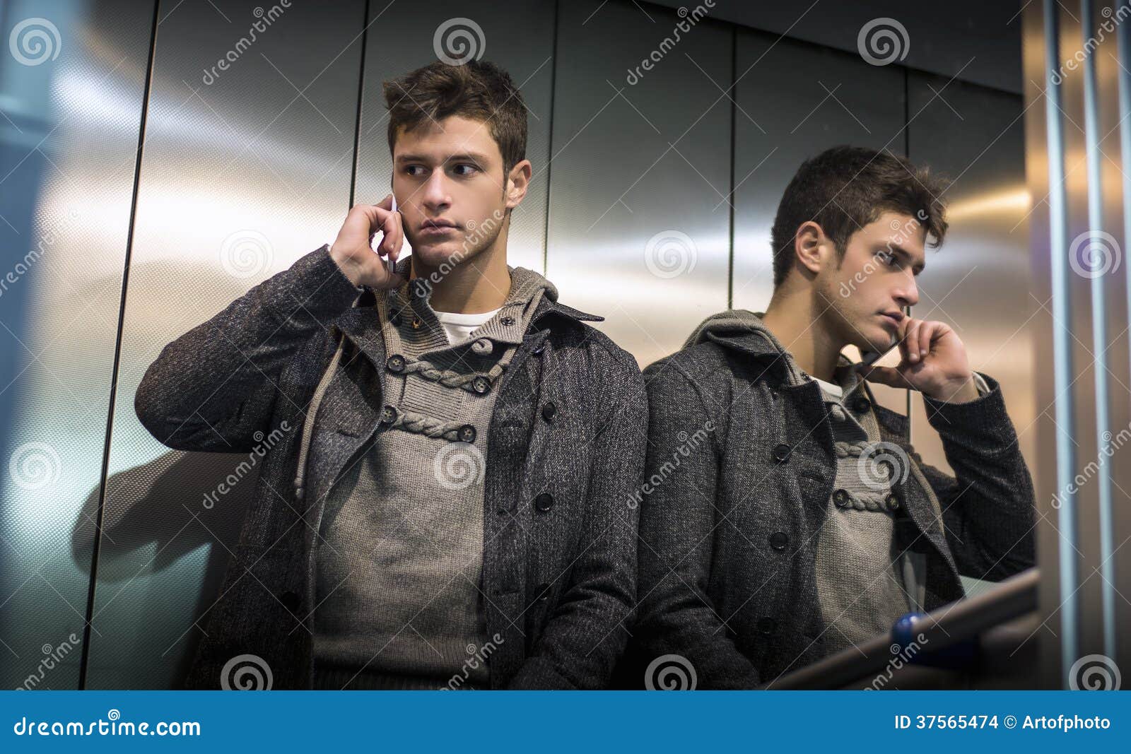 Handsome Young Man in Elevator (lift) Using Cell Phone Stock Photo ...