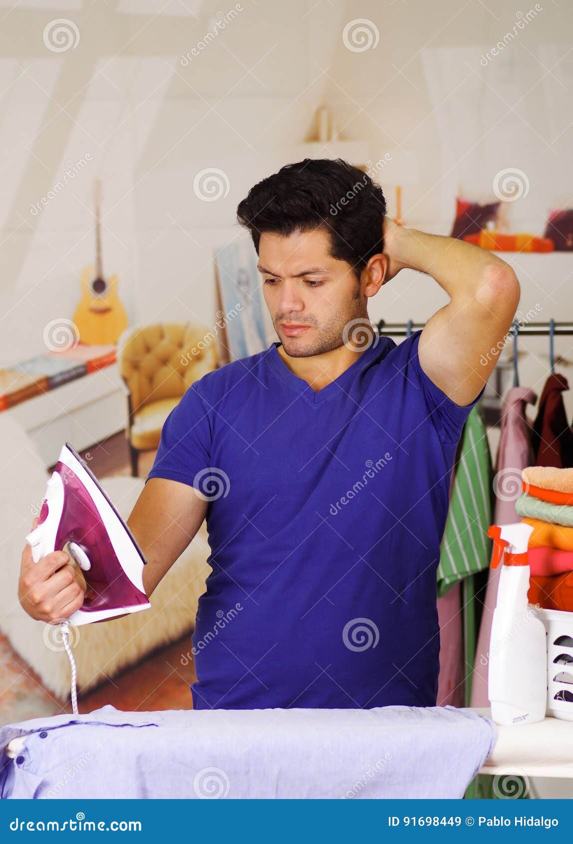 Handsome Young Man Holding an Iron in His Hand Using a Blue T-shirt ...