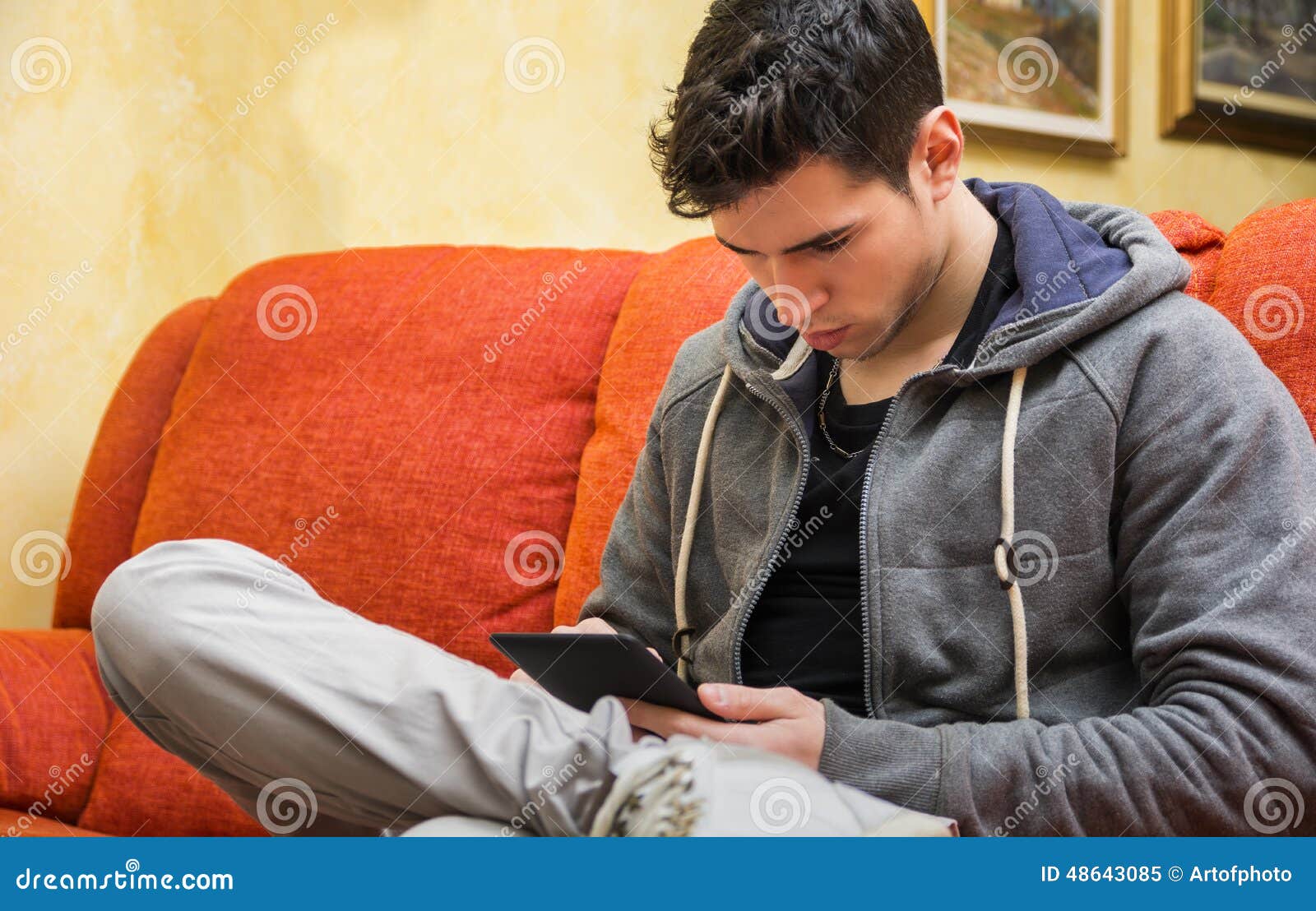 Handsome Young Man at Home Reading with Ebook Stock Image - Image of ...