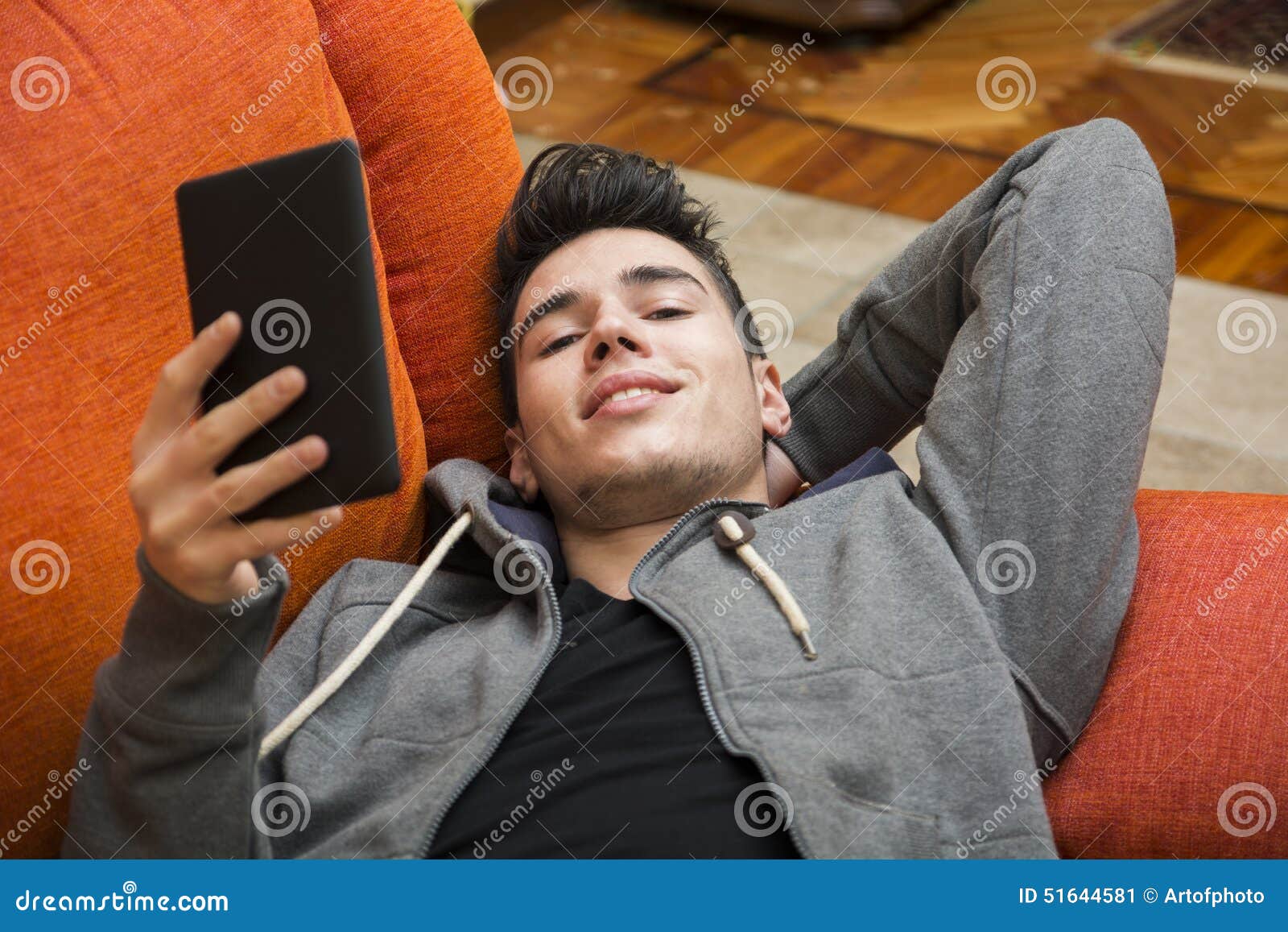 Handsome Young Man at Home Reading with Ebook Reader Stock Image ...