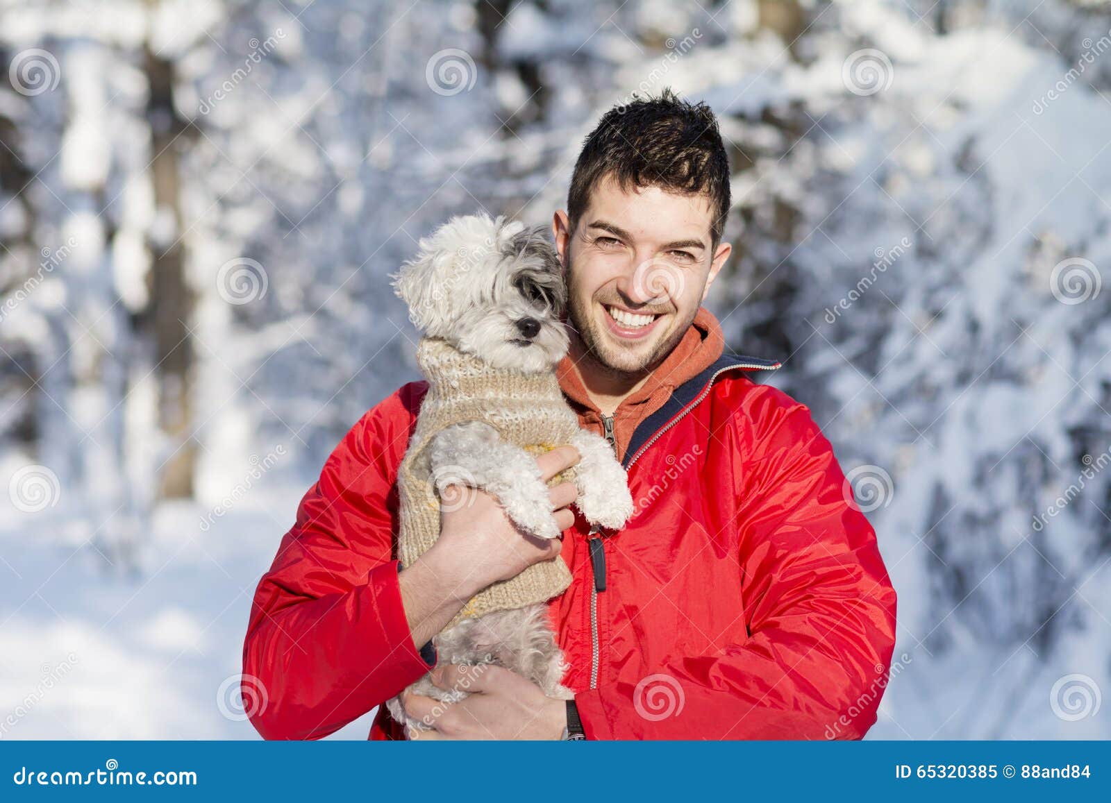 Handsome Young Man Hugging His Small White Dog in the Winter.Snowing ...