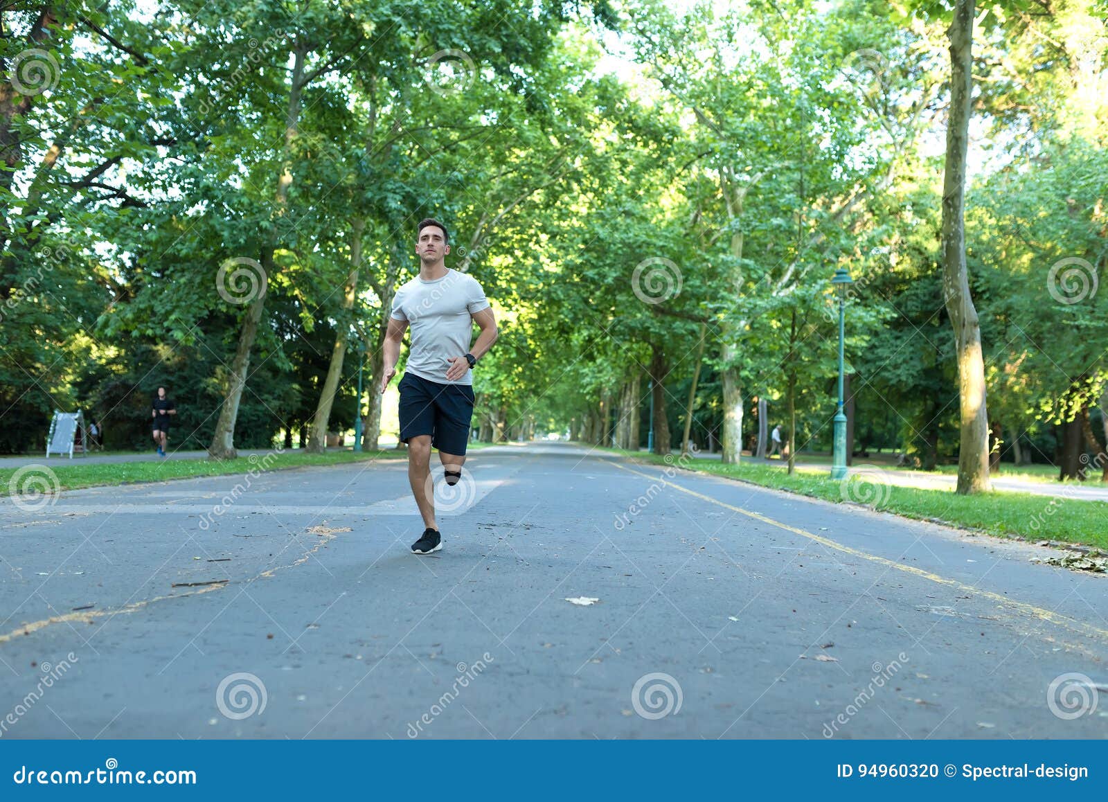 A Handsome Young Man Jogging in a Park Stock Photo - Image of body ...