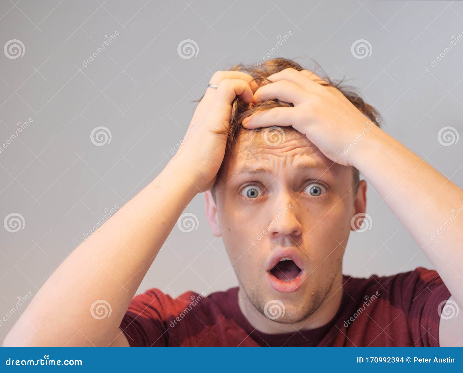 A Handsome Young Man Looking Shocked with His Hands on His Head Stock ...