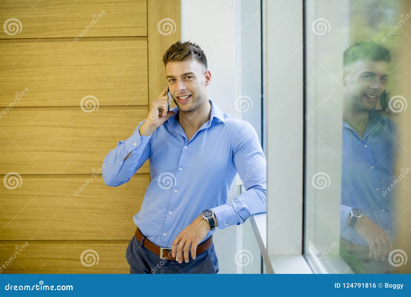 Handsome Young Man with Mobile Phone in Office Stock Photo - Image of ...