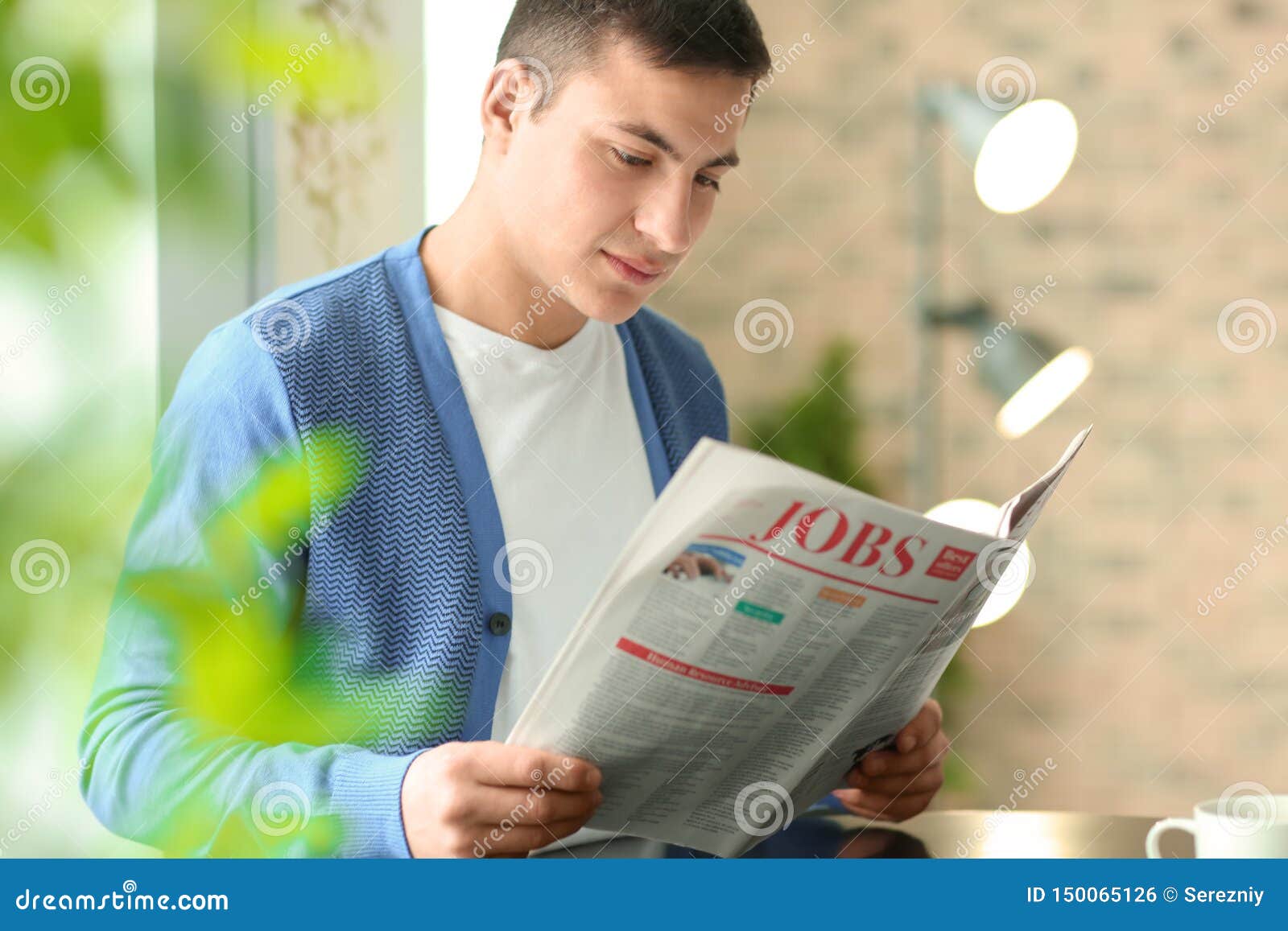 Handsome Young Man Reading Newspaper in Cafe Stock Photo - Image of ...