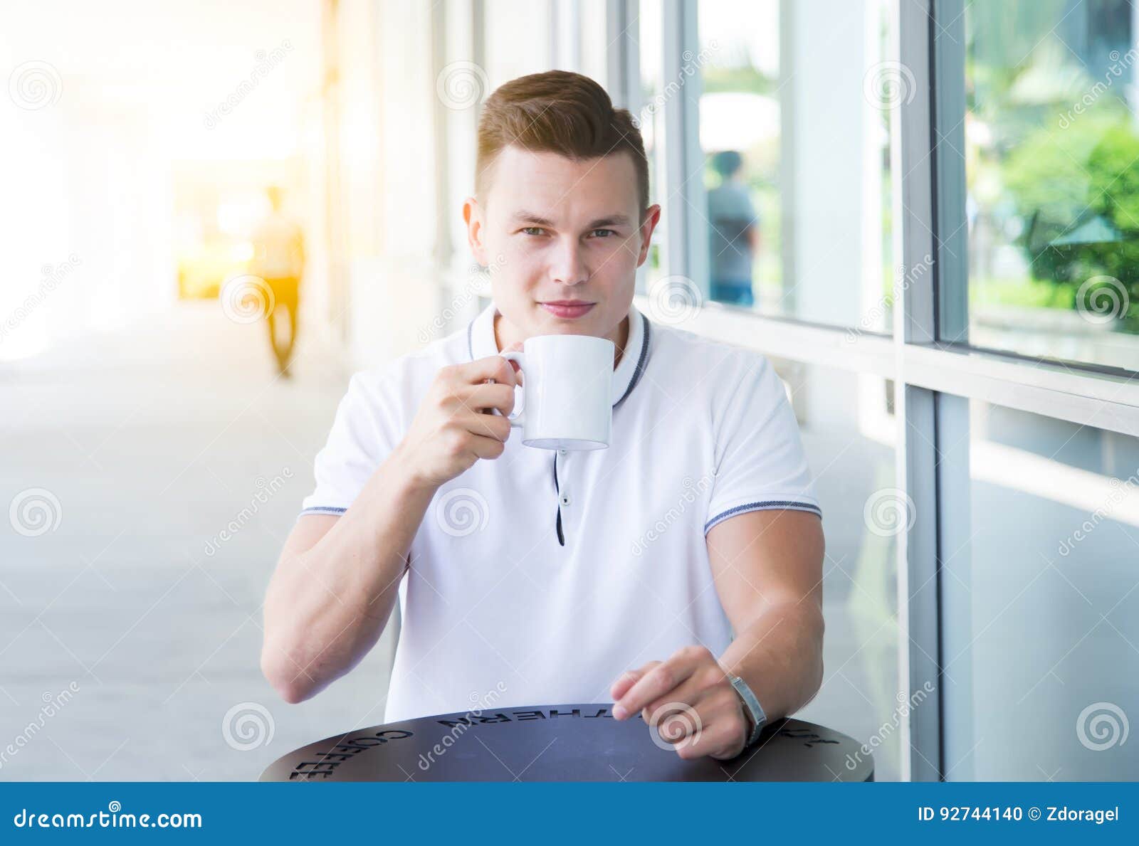 Handsome Young Man Sitting and Drinking Coffee in a Cafe Stock Photo ...