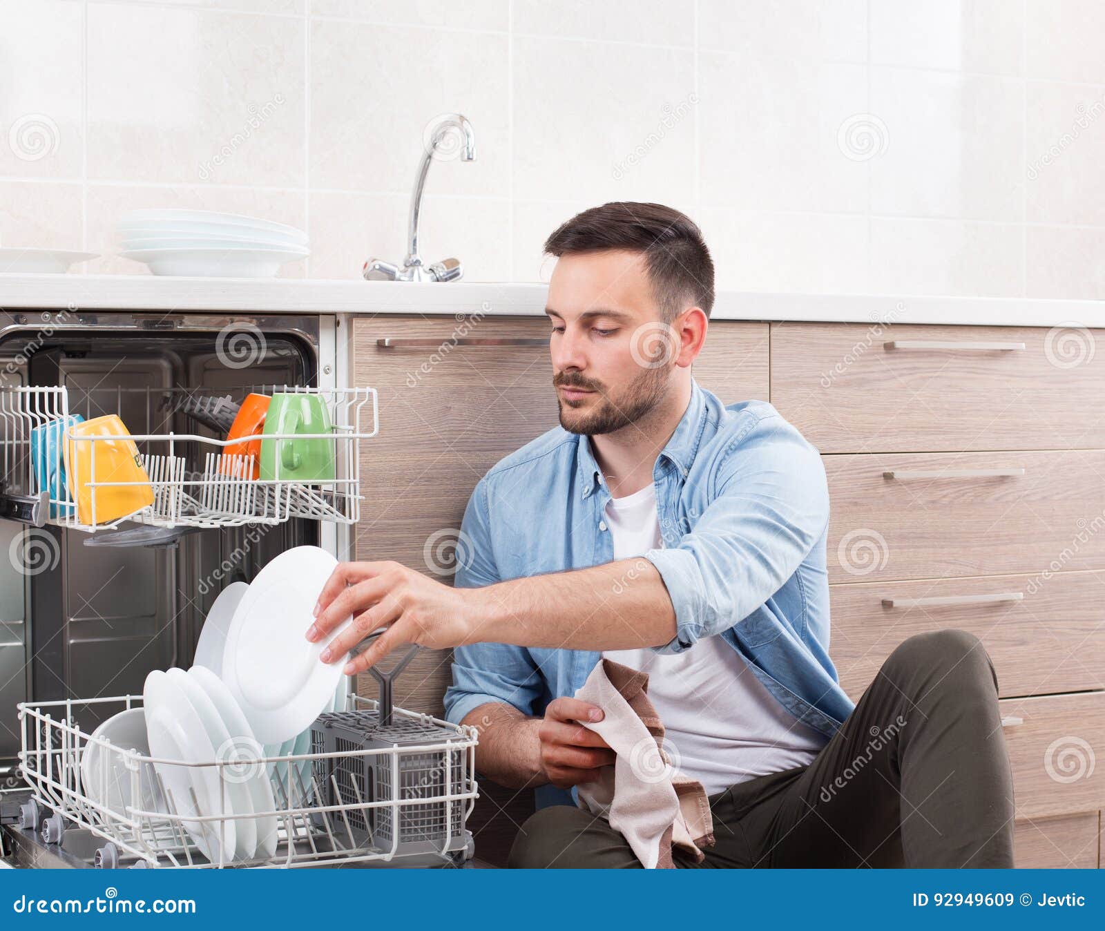 Man unloading dishwasher stock image. Image of attractive - 92949609