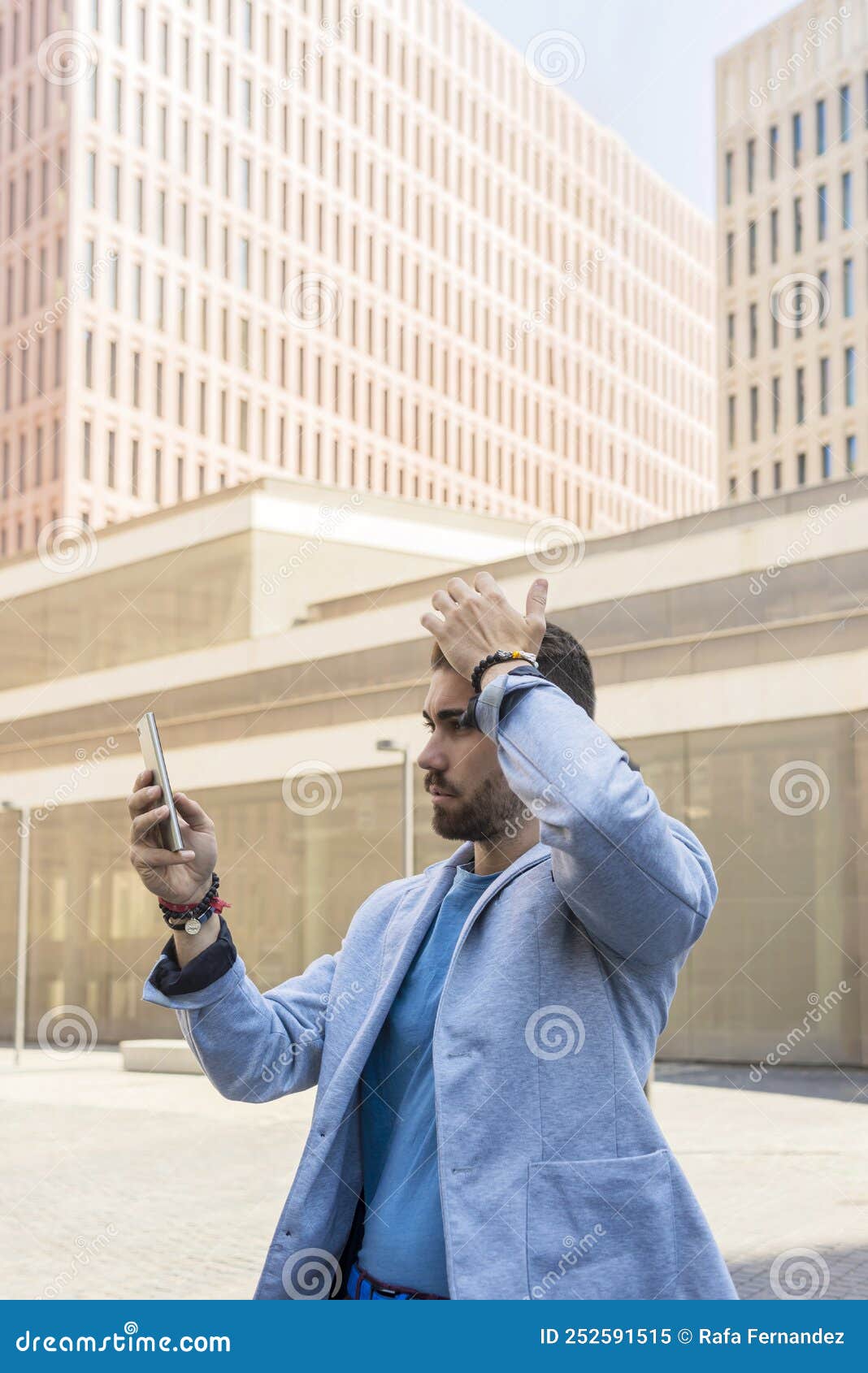 Handsome Young Man Smiling when he is Using His Mobile Phone Stock ...
