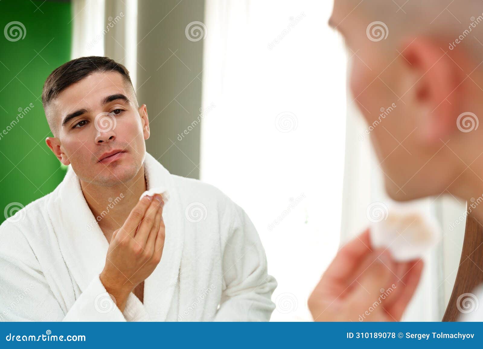 Handsome Young Man Using Cotton Pad on His Face in Bathroom Stock Photo ...