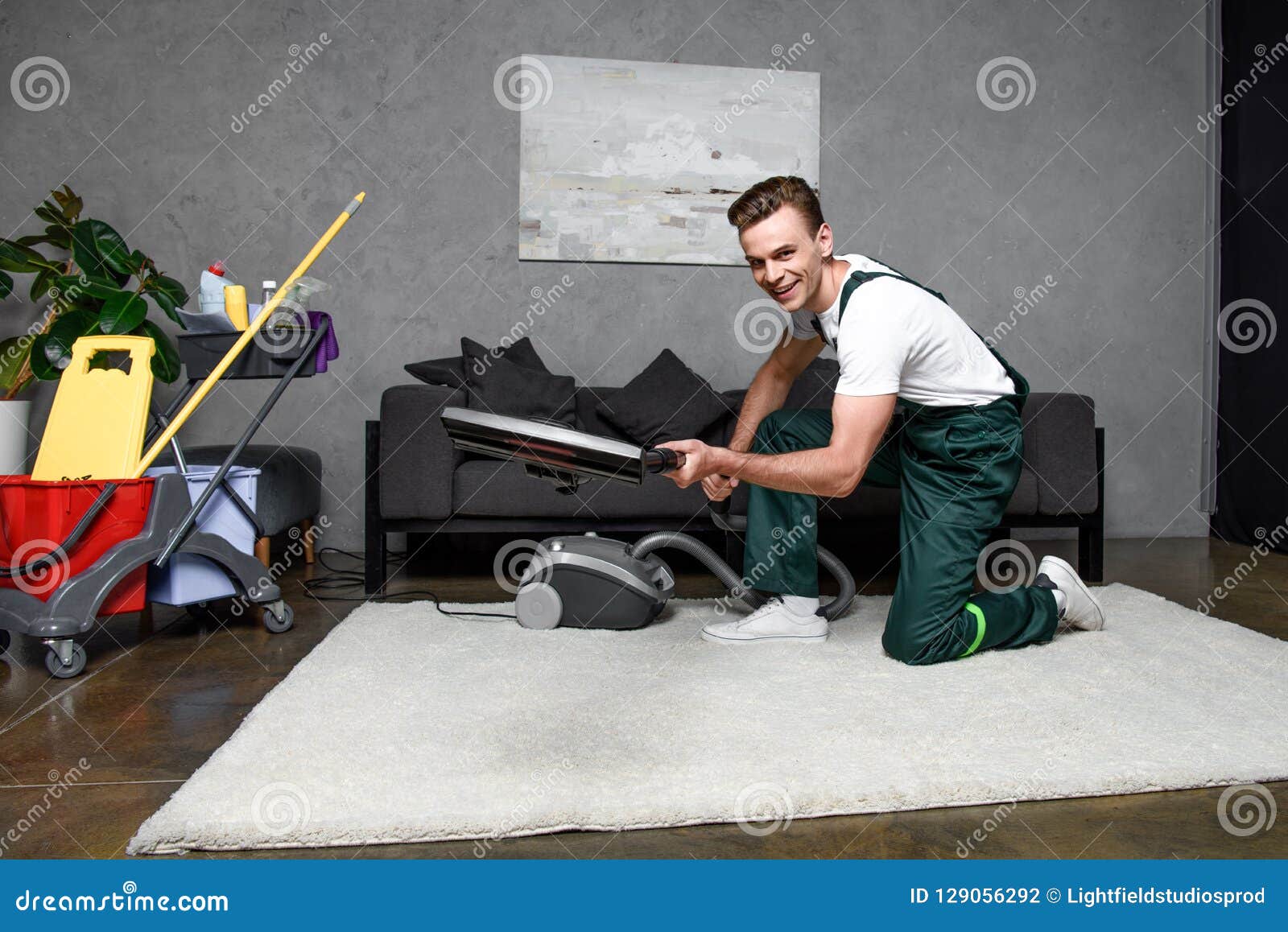Handsome Young Man Using Vacuum Cleaner and Smiling at Camera ...