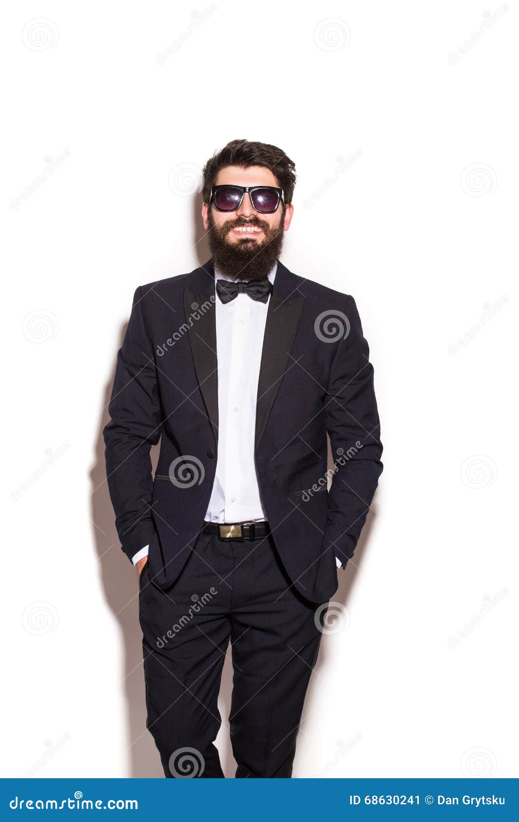Handsome Young Man Wearing Suit And Glasses Keeping Hands In Pockets And Looking At Camera Stock
