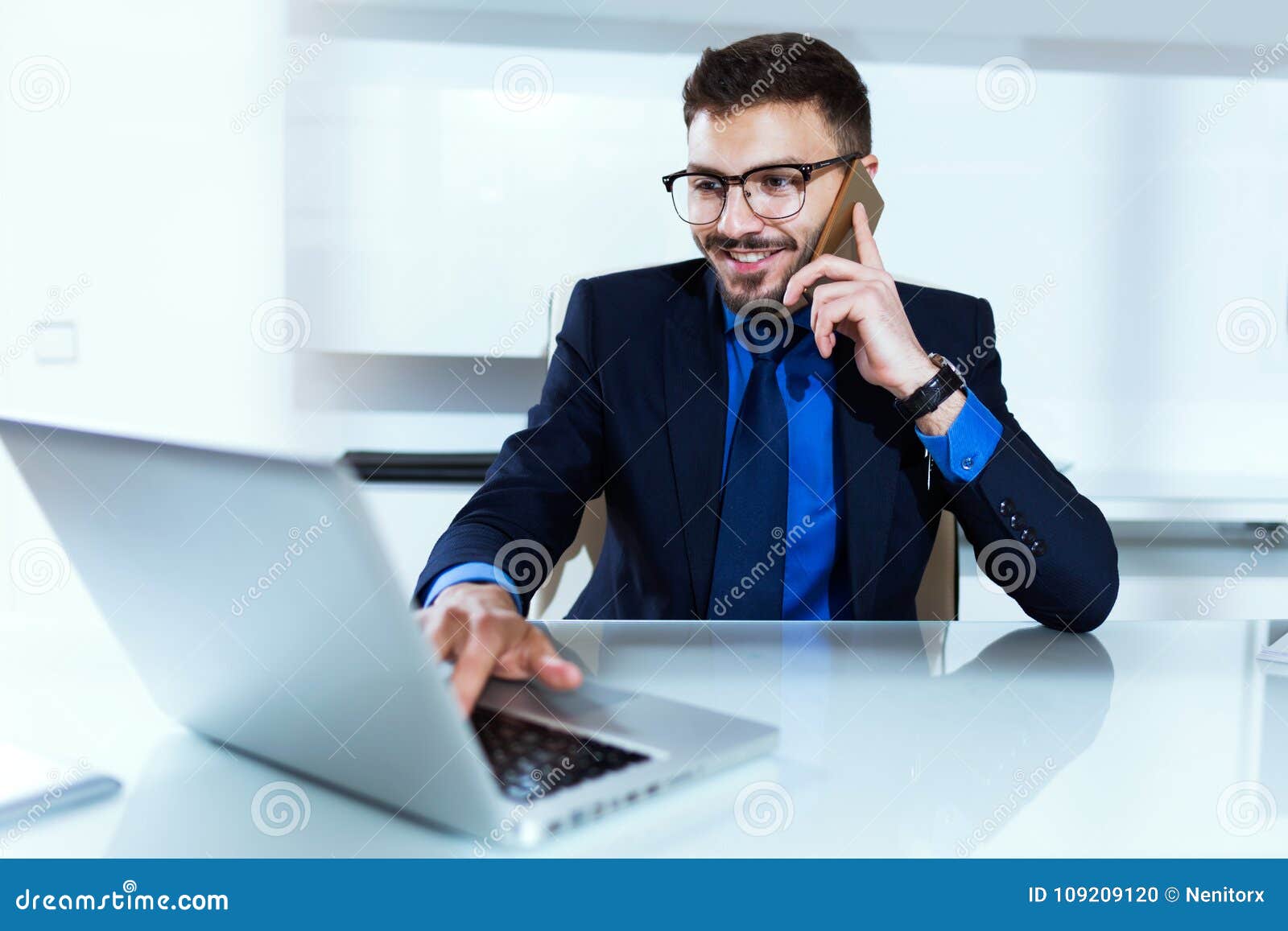 Handsome Young Man Working with Laptop and Mobile Phone in the Office ...