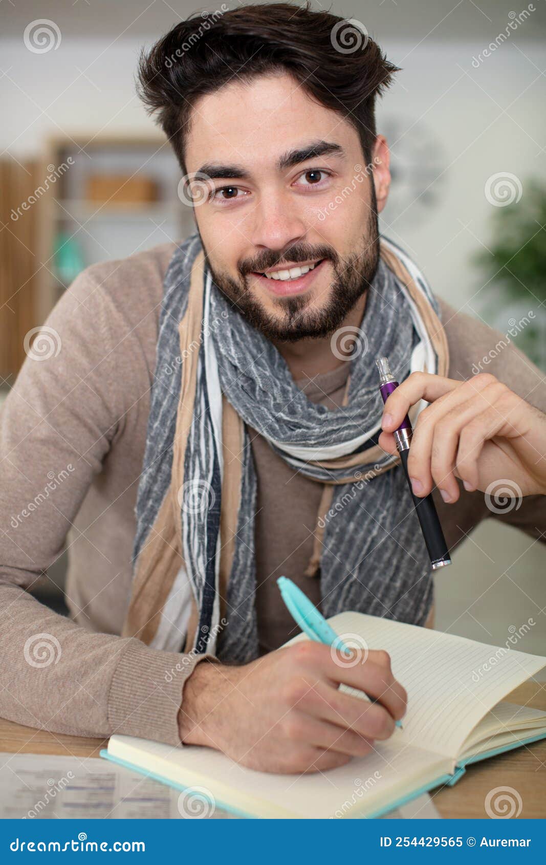 Handsome Young Man Writing Something in Note Pad Stock Image - Image of ...