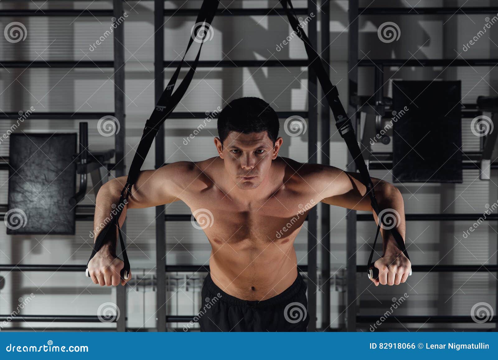 Handsome Young Muscled Man Training with Trx while Working Out in Gym ...