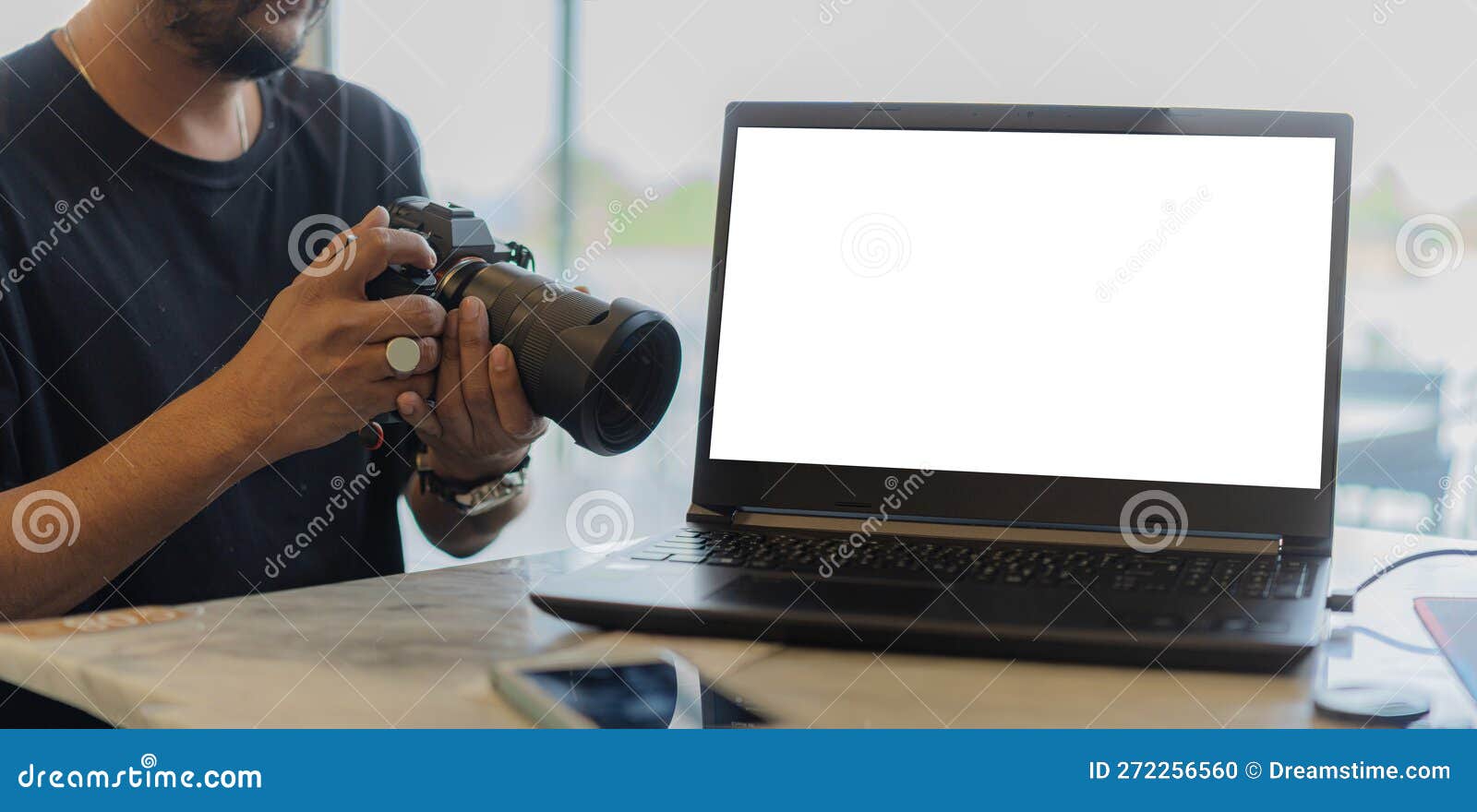 Handsome Young Photographer Using a Camera while Working with a Laptop ...