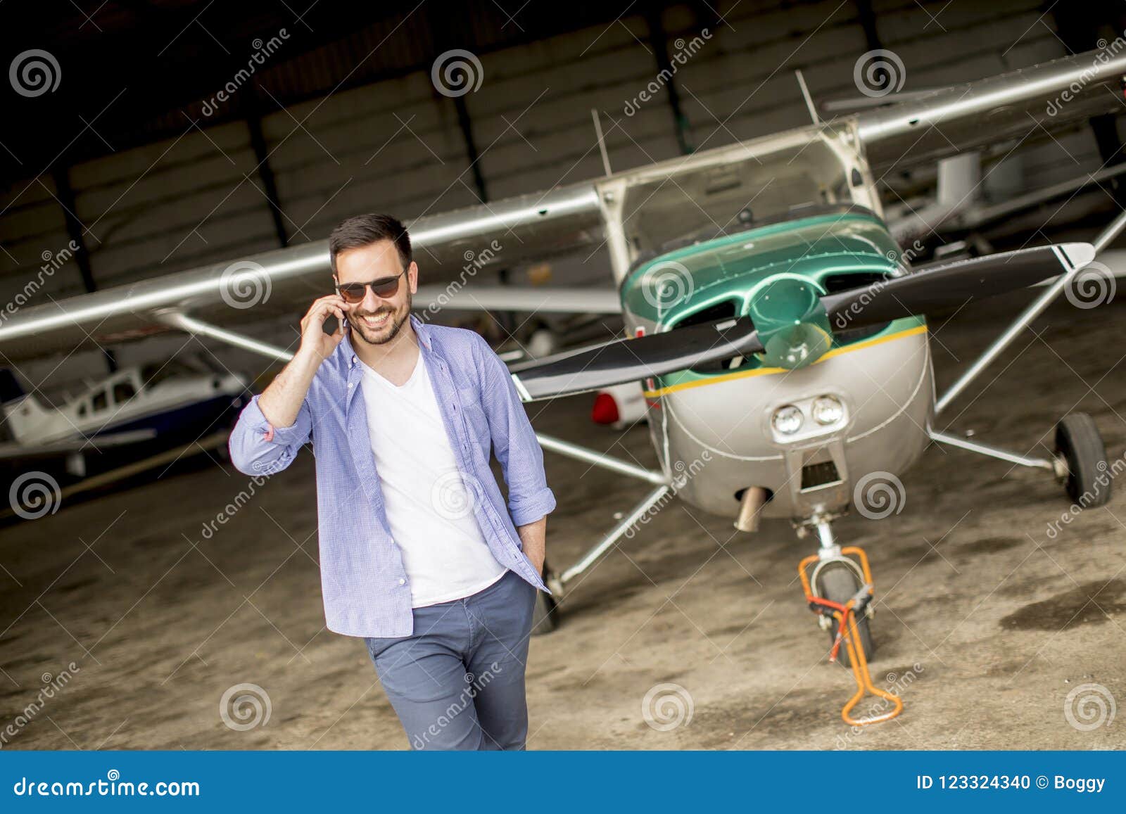 Handsome Young Pilot Checking Airplane in the Hangar and Using M Stock ...