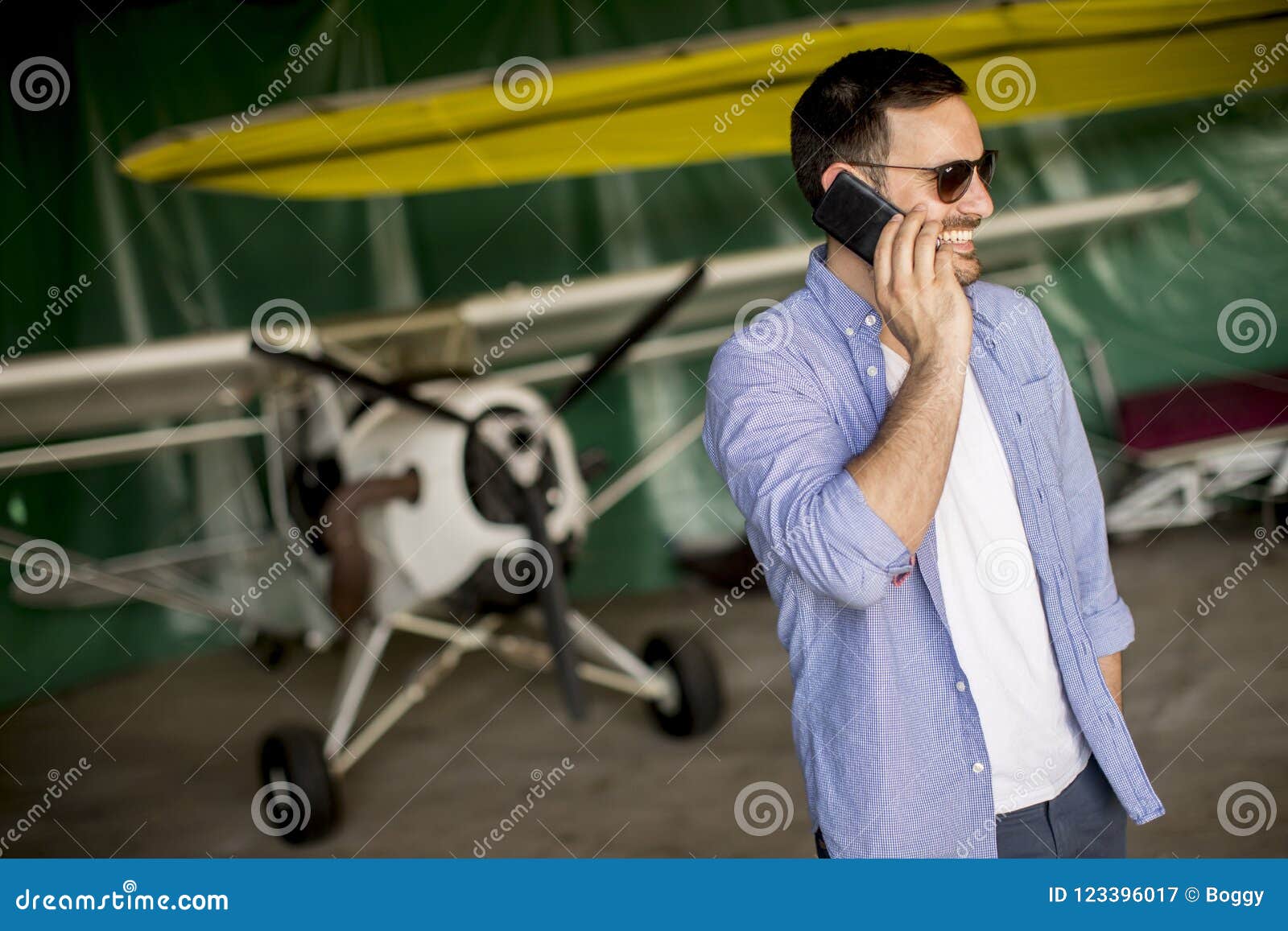 Handsome Young Pilot Checking Airplane in the Hangar and Using M Stock ...