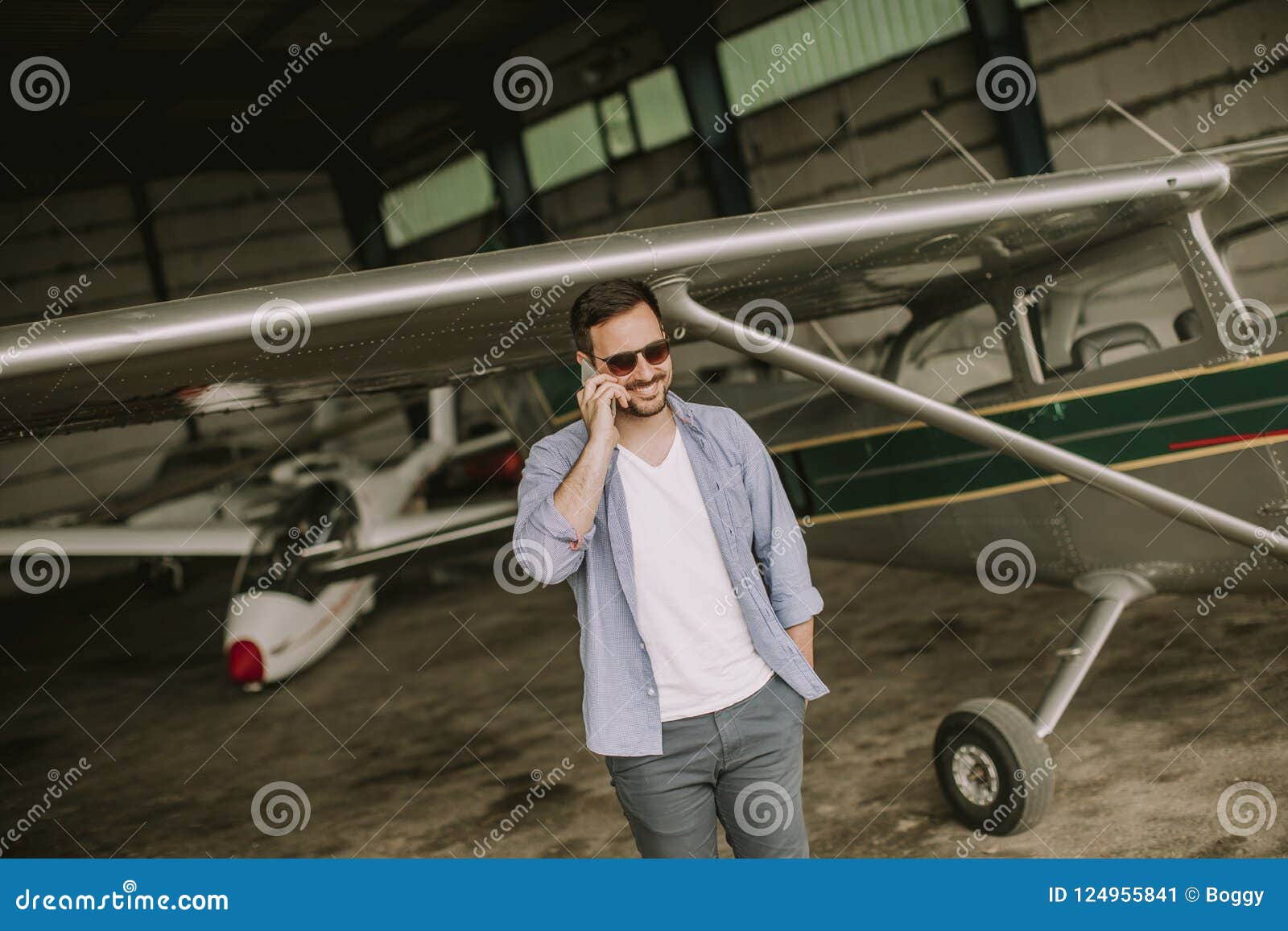 Handsome Young Pilot Checking Airplane in the Hangar and Using M Stock ...