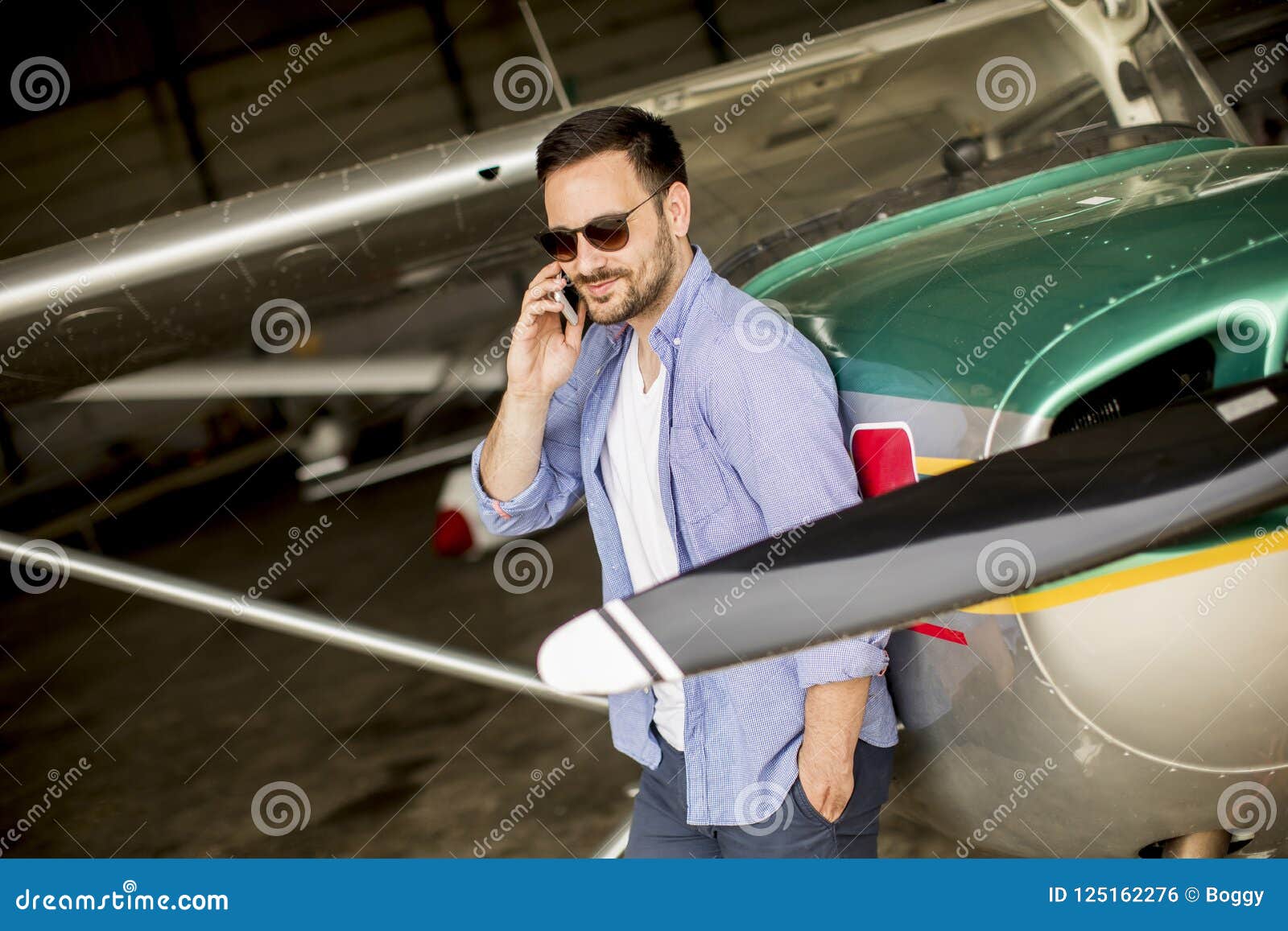 Handsome Young Pilot Checking Airplane in the Hangar and Using M Stock ...