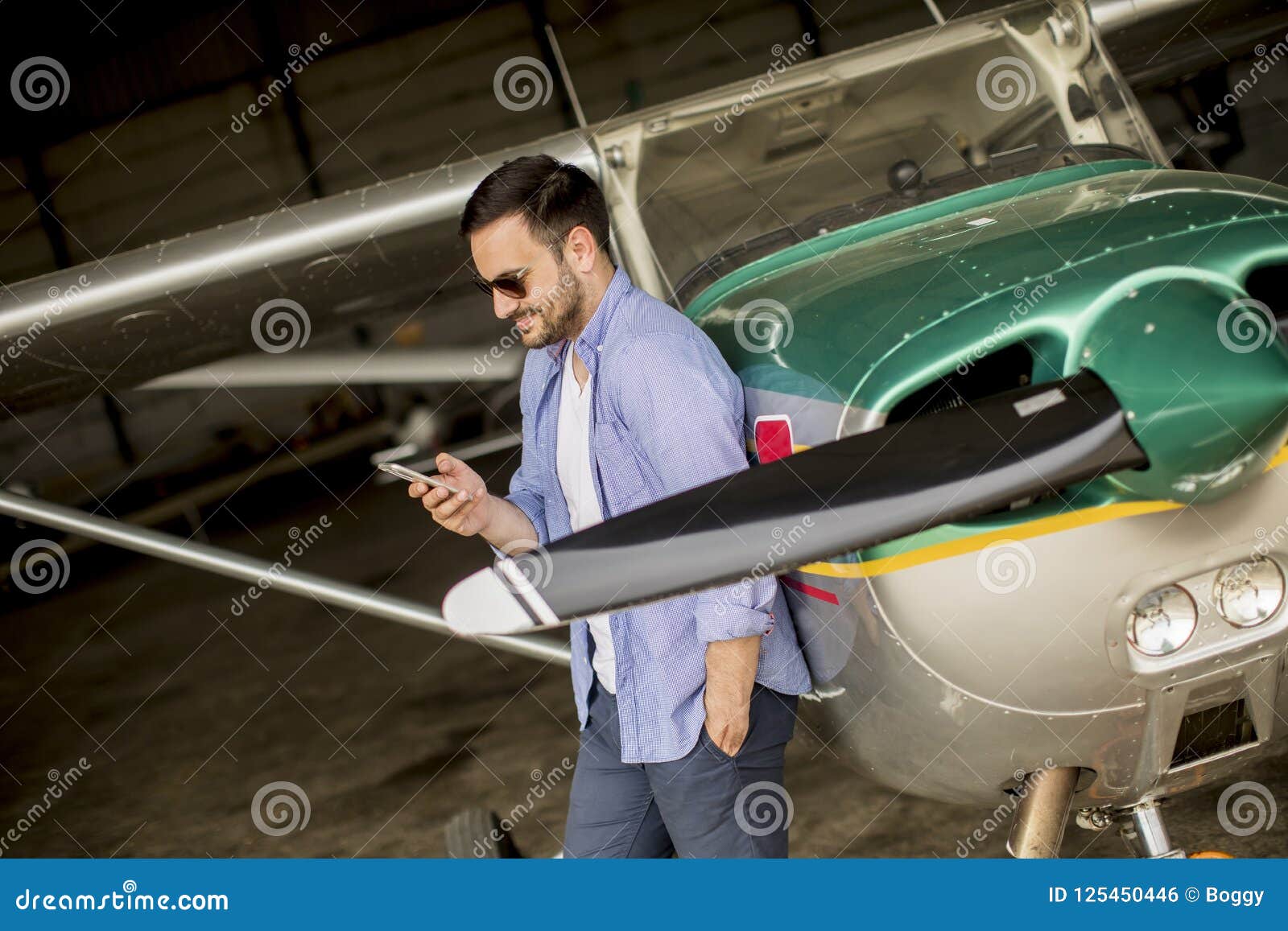 Handsome Young Pilot Checking Airplane in the Hangar and Using M Stock ...