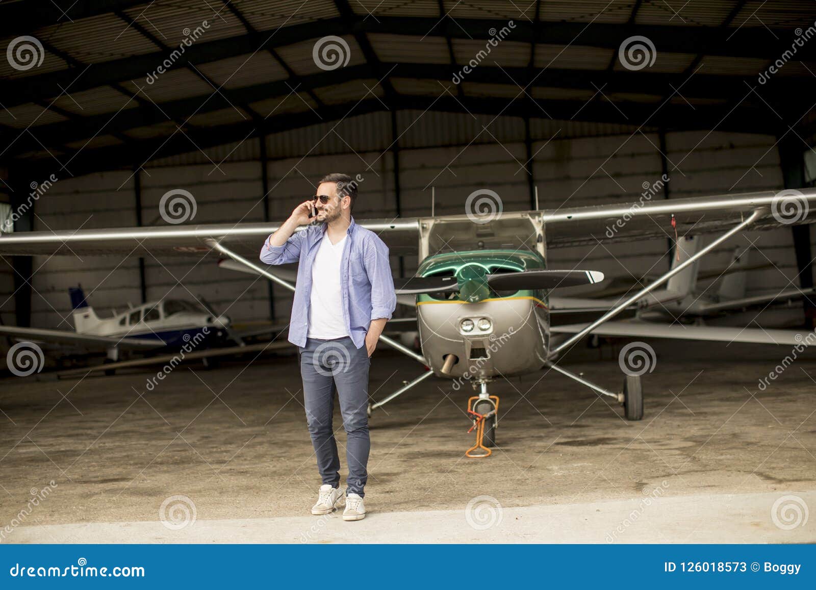 Handsome Young Pilot Checking Airplane in the Hangar and Using M Stock ...