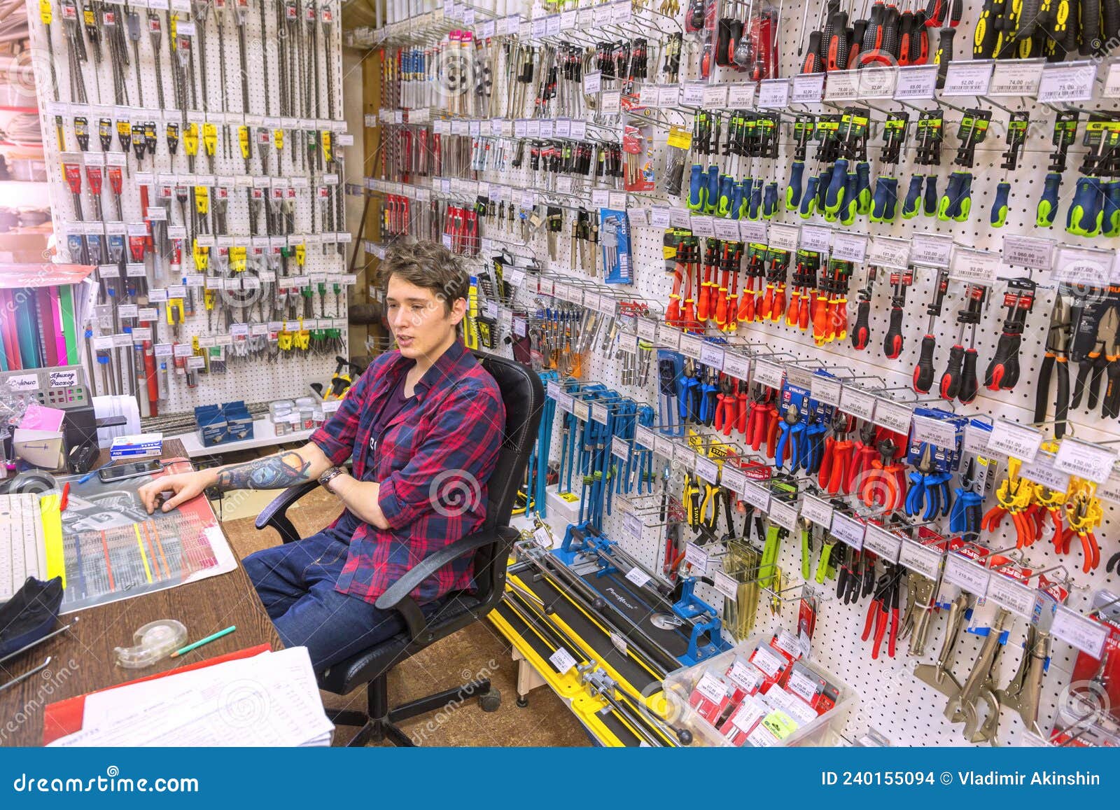 A Handsome Young Seller of Locksmith Tools at His Workplace at a Table ...
