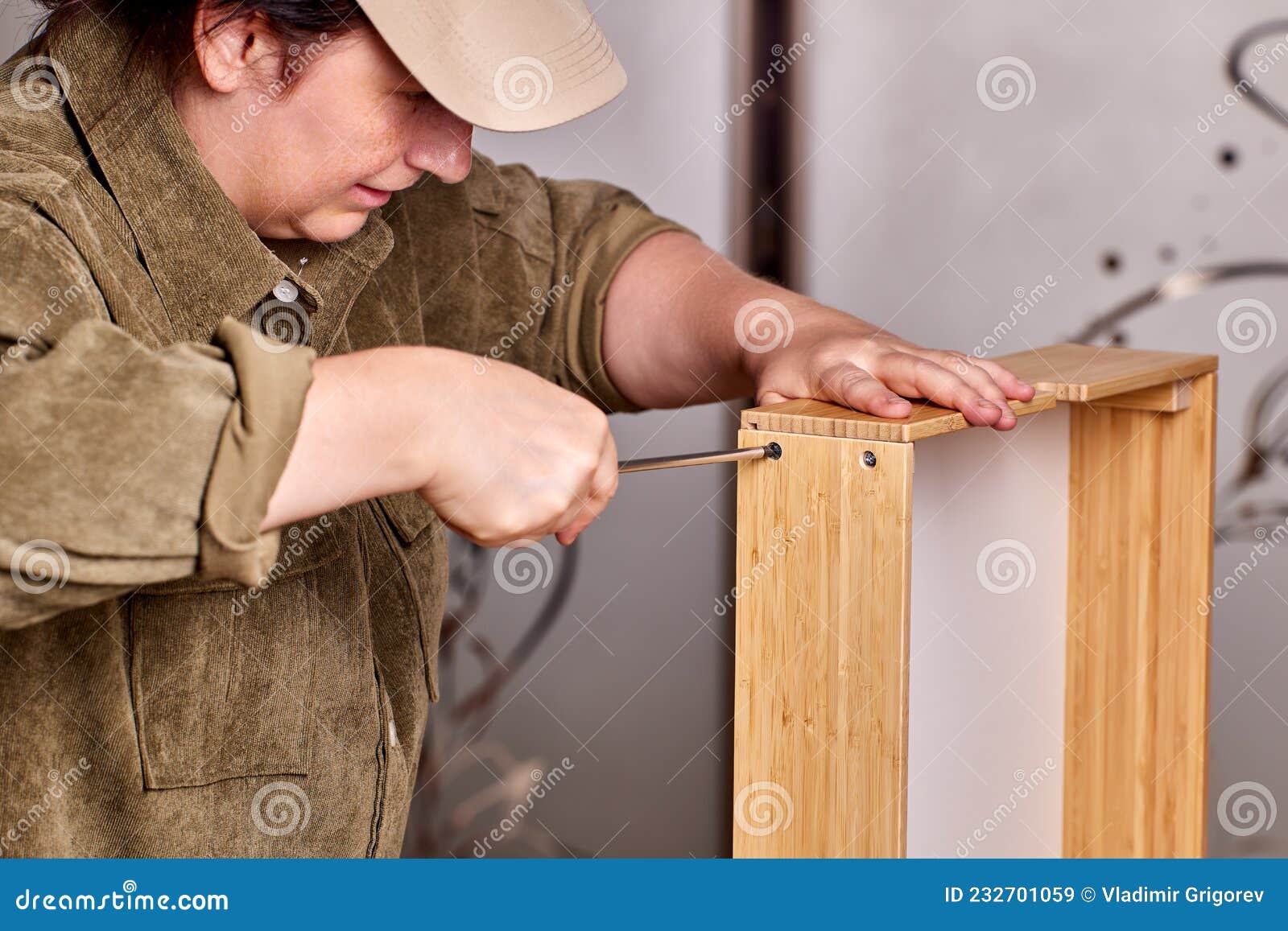 Handyman Is Assembling Drawer Of Flat Pack Furniture By Screwdriver