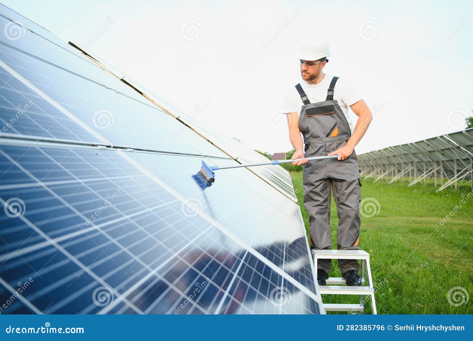 A Handyman Cleaning Solar Panels Form Dust and Dirt. Stock Photo ...