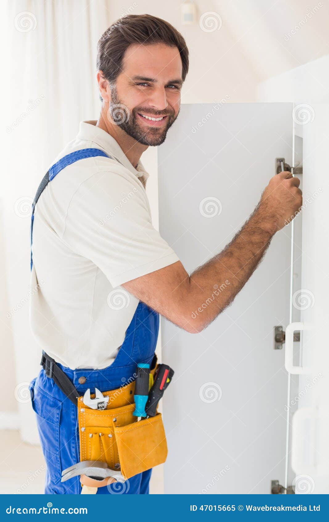 Handyman fixing a wardrobe stock image. Image of male - 47015665