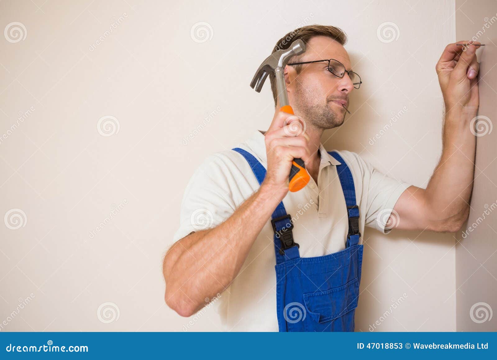 Handyman Hammering Nail in Wall Stock Image - Image of holding ...