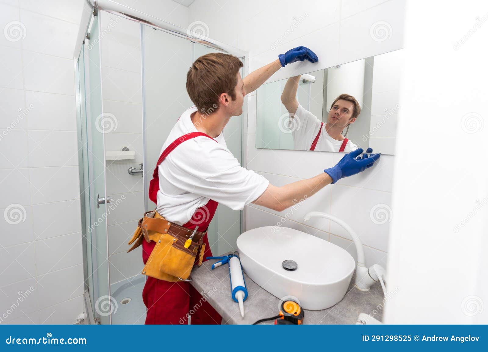 Handyman Installing a Mirror in Bathroom. Stock Image - Image of ...