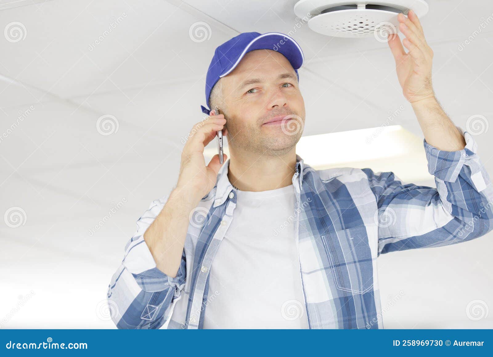 Handyman Installing Smoke Detector Calling with Phone Stock Photo ... Handyman Installing Smoke Detector Calling with Phone Stock Photo ...