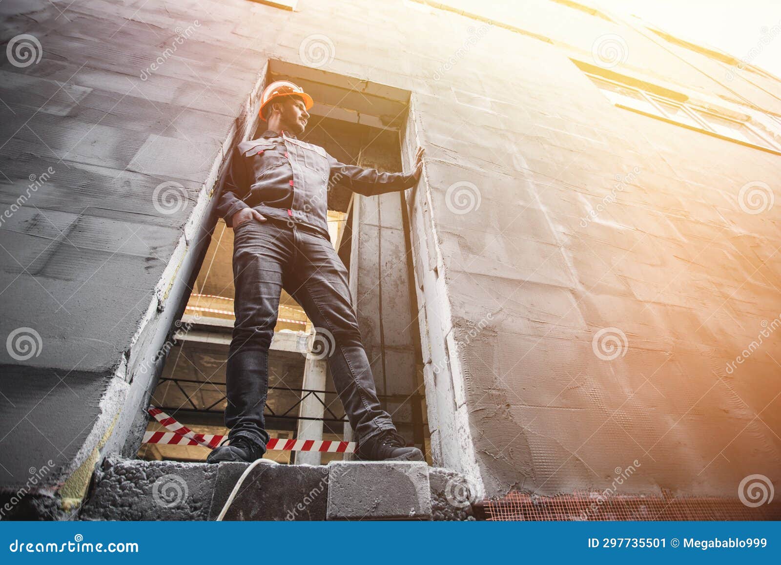 A Handyman in Overalls and a Hard Hat Stands in the Opening of a ...