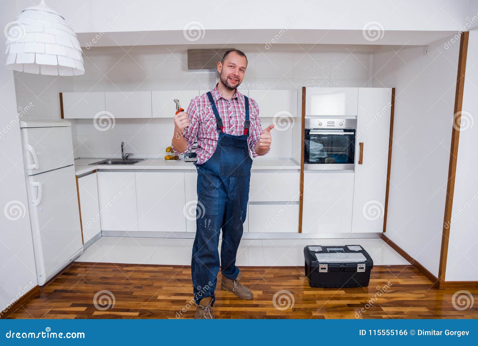 Handyman in Uniform Standing Next To the Toolbox in the Kitchen Stock ...