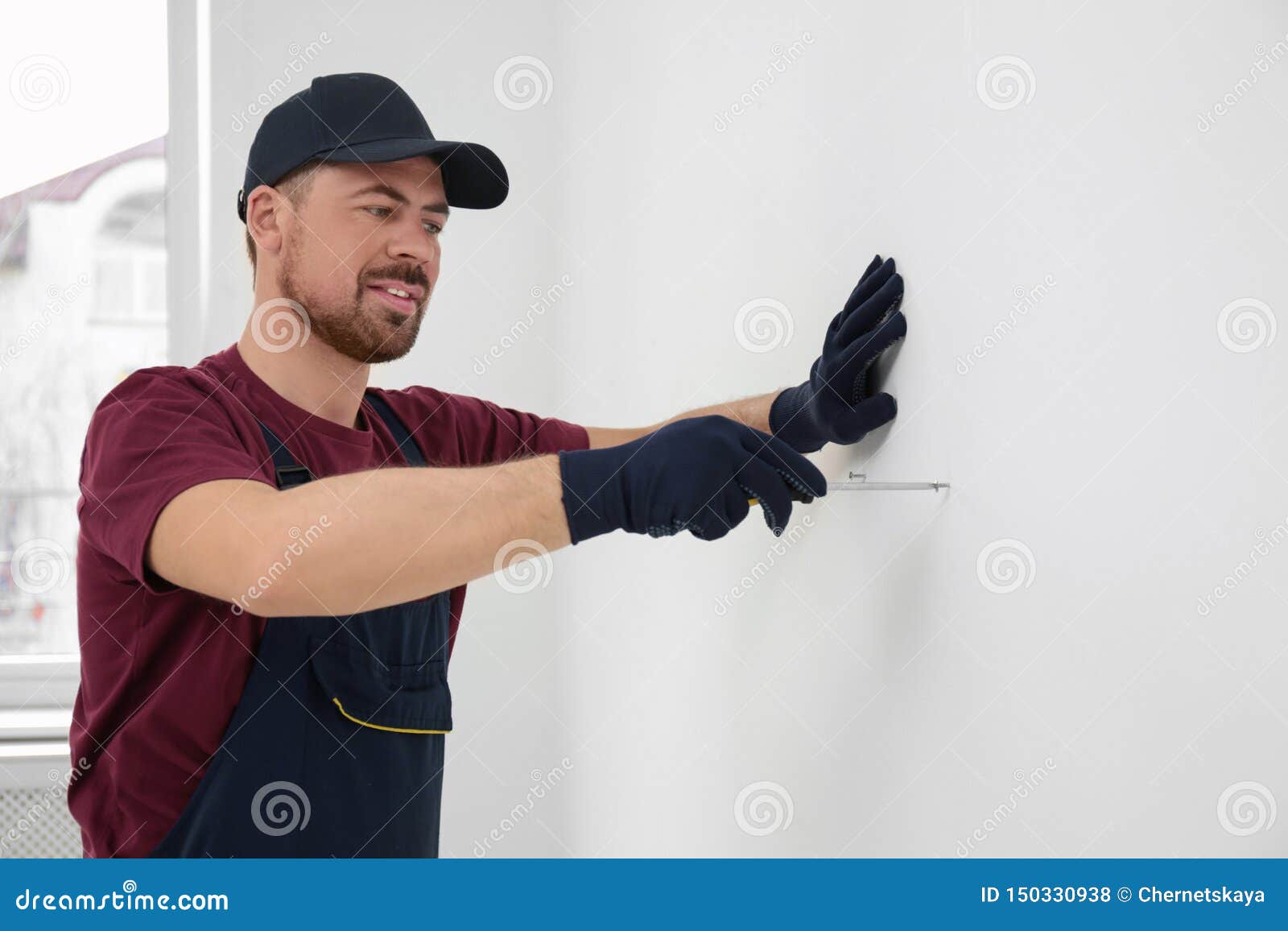 Handyman in Uniform Working with Screwdriver. Professional Construction ...