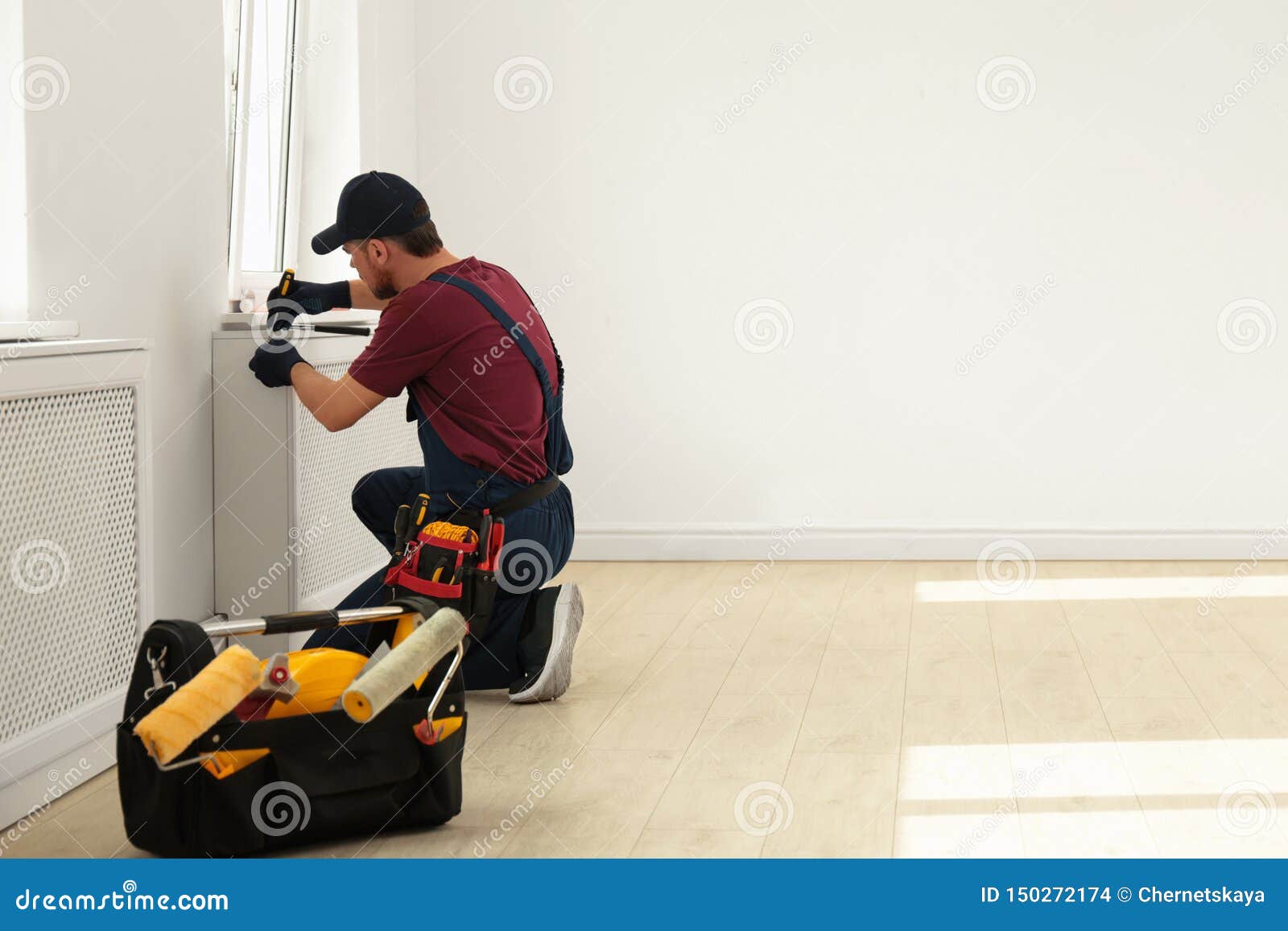Handyman in Uniform Working with Screwdriver Indoors. Professional ...