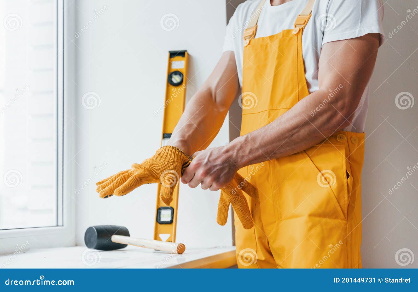Handyman in Yellow Uniform Preparing for Work Indoors. House Renovation ...