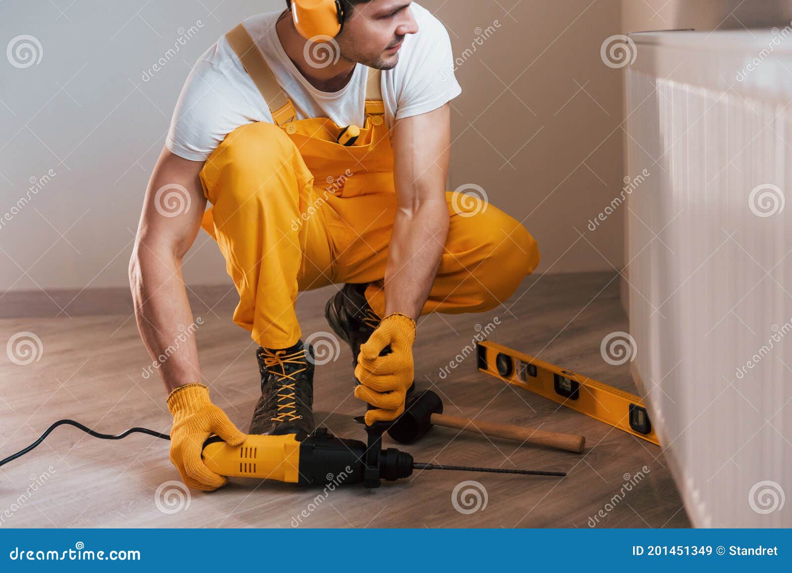 Handyman in Yellow Uniform Works Indoors by Using Hammer Drill. House ...