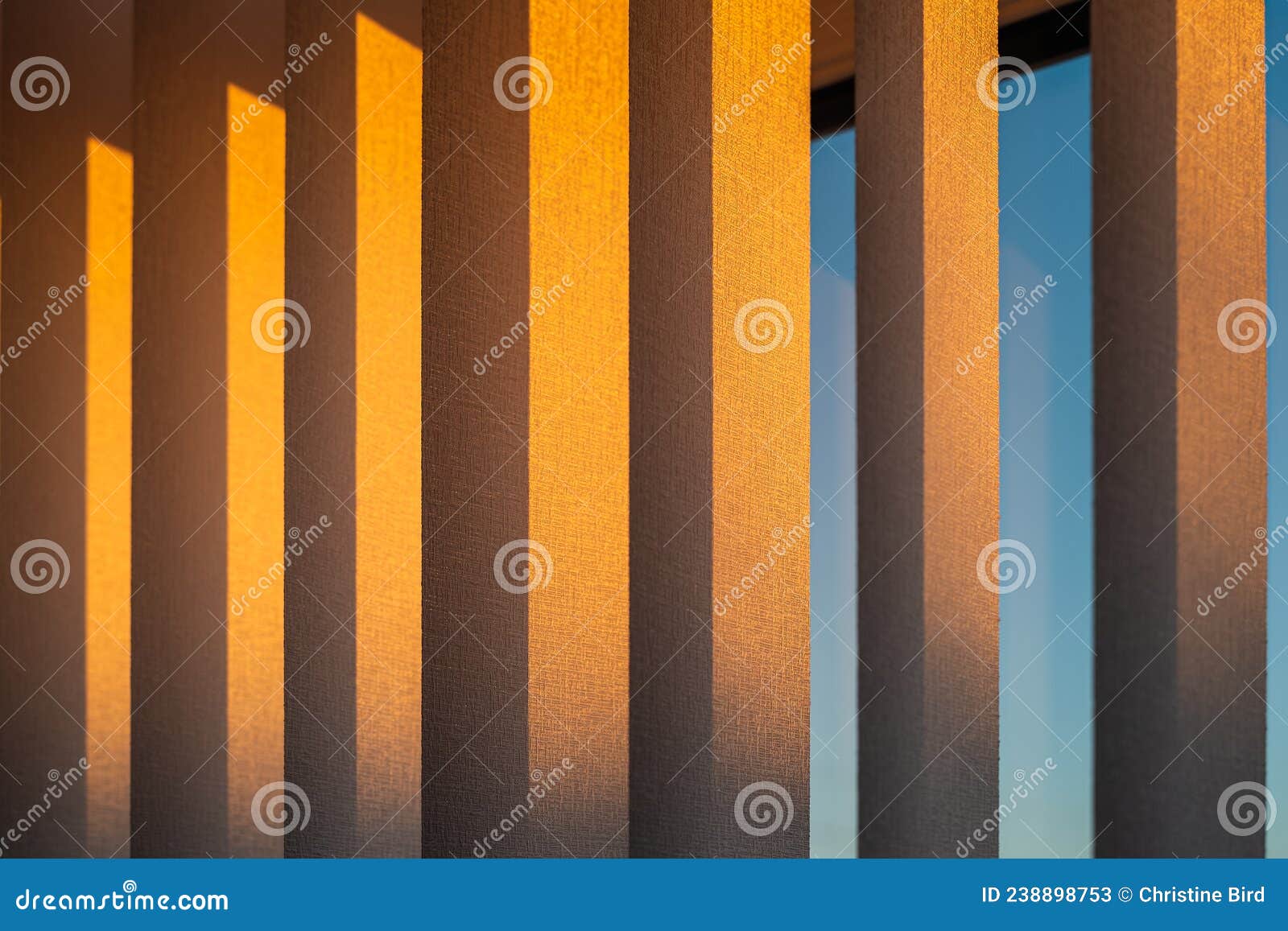 Hanging White Textured Vertical Window Slats Reflecting the Gold of a ...