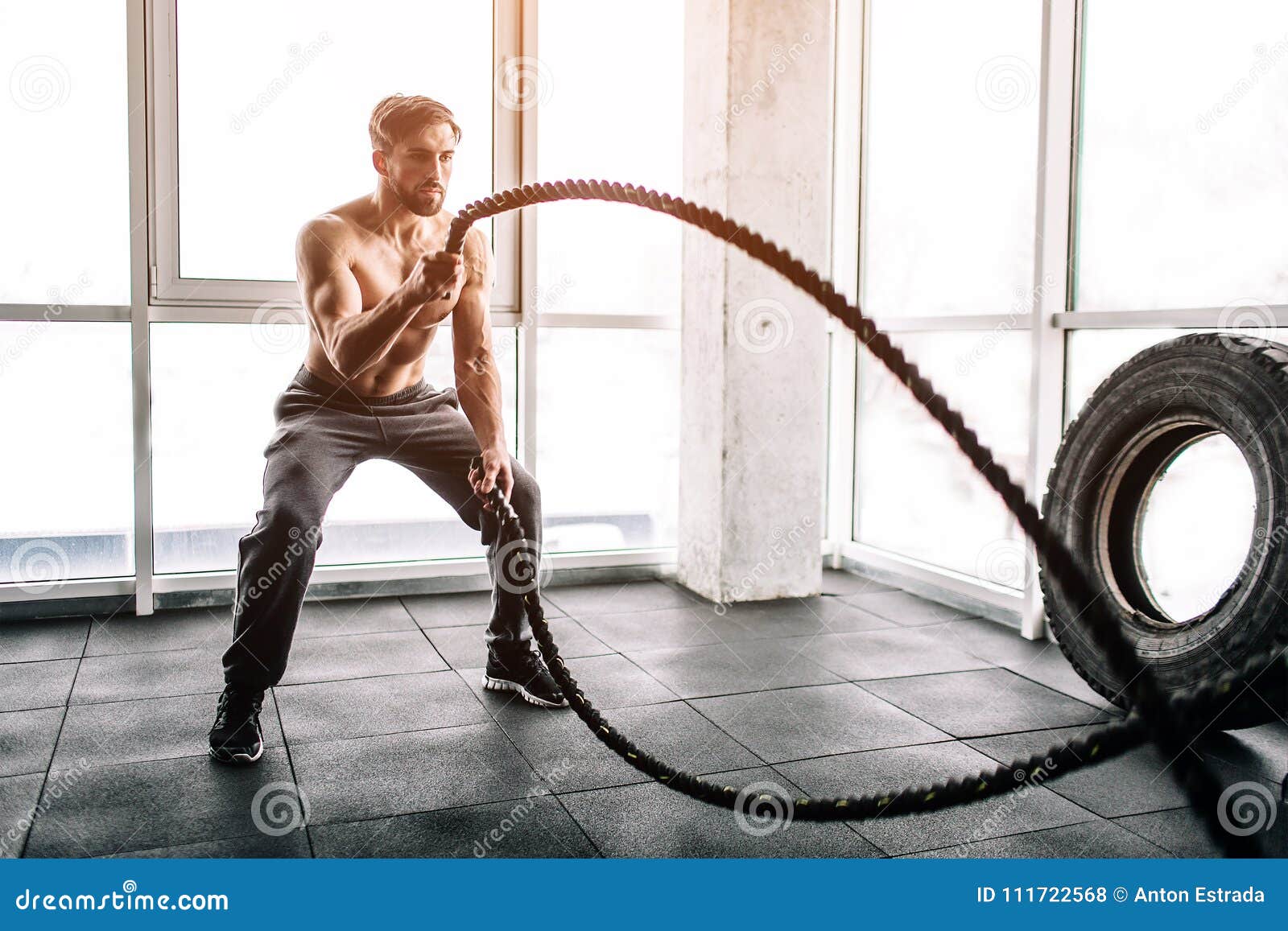 Hansome and Well-built Man is Doing Some Exercises with Waving Two Big ...