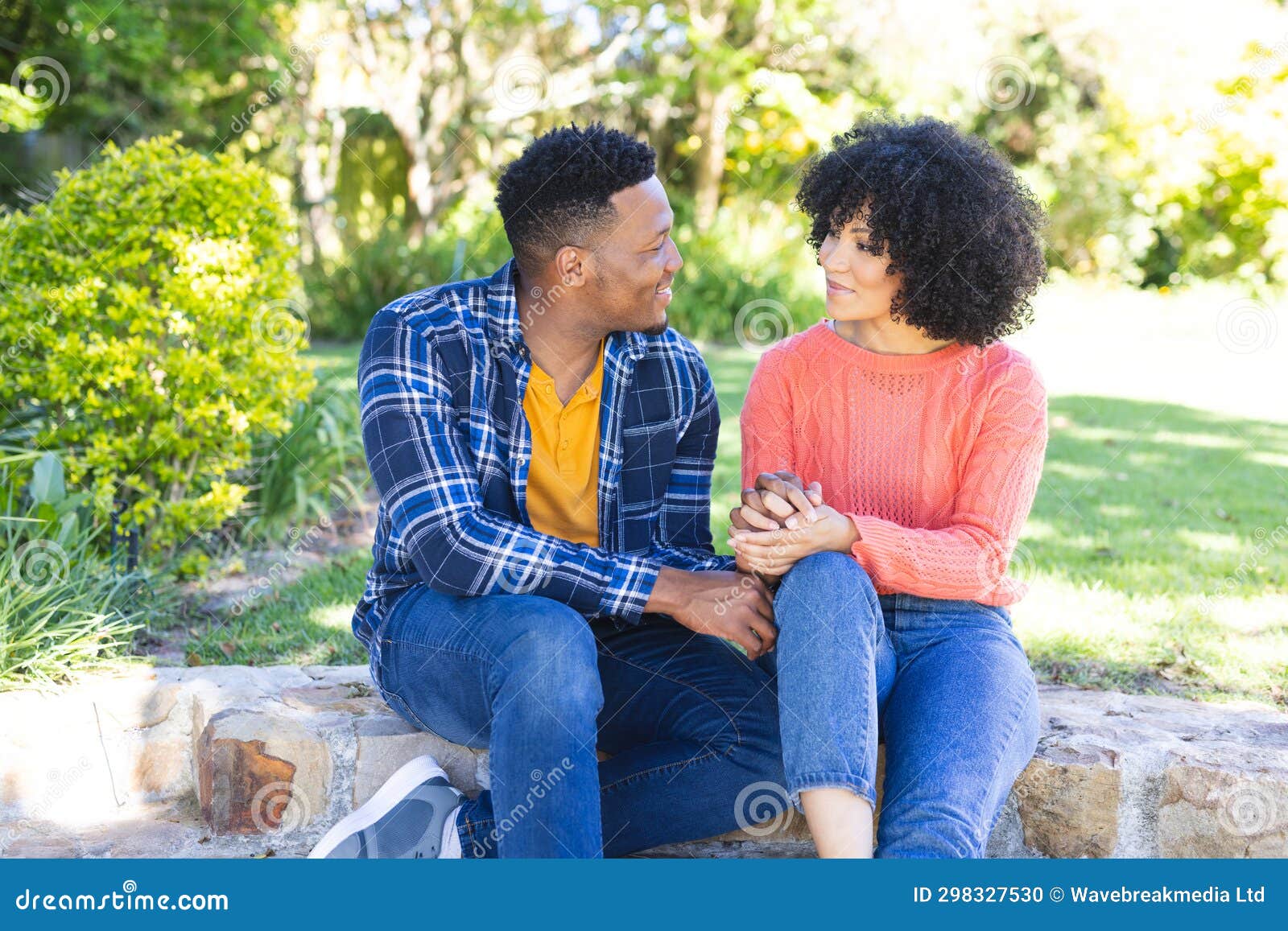Happy African American Couple Sitting On Stairs And Holding Hands In
