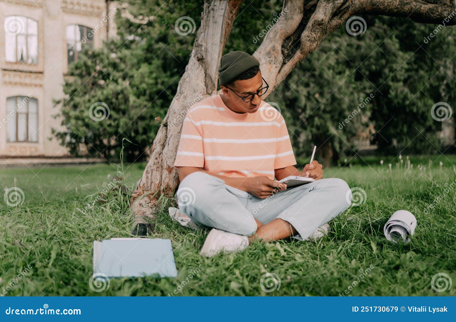 Happy African American Guy Writing Something in Notebook, Sitting in ...