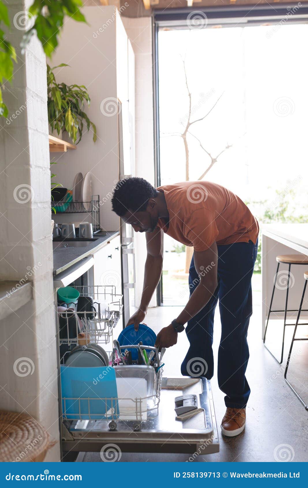 Happy African American Man Celaning, Unloading Dishwasher in Kitchen ...