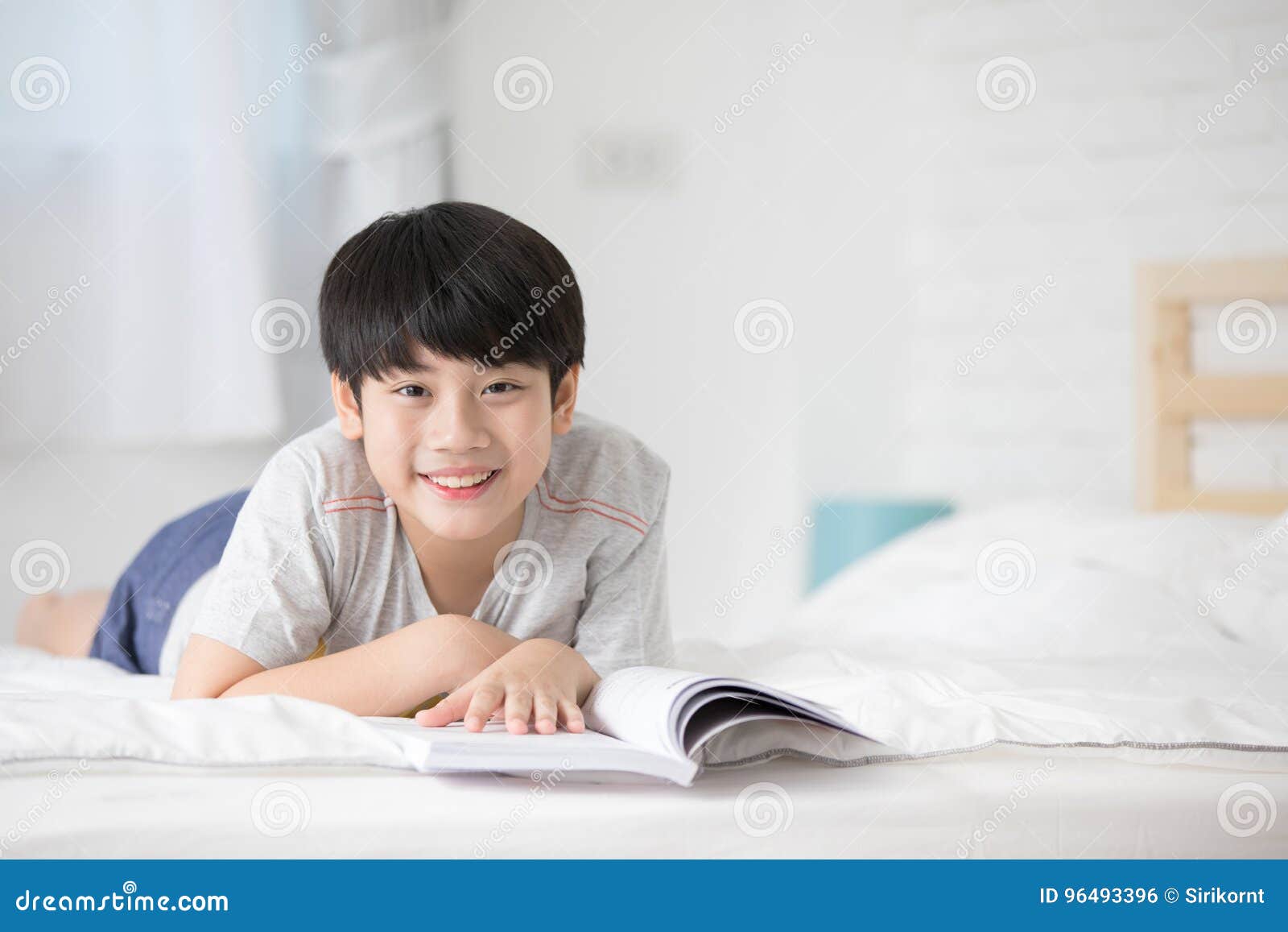 Happy Asian Boy Reading Story Book on the Bed Stock Photo - Image of ...