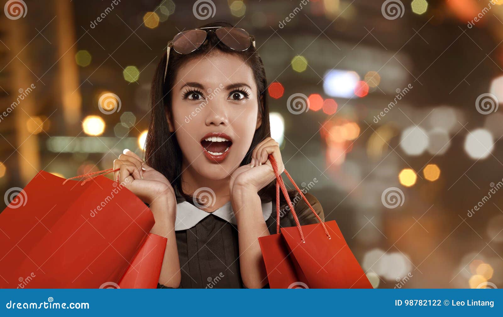 Happy Asian Woman With Red Shopping Bag Celebrating Black Friday Stock