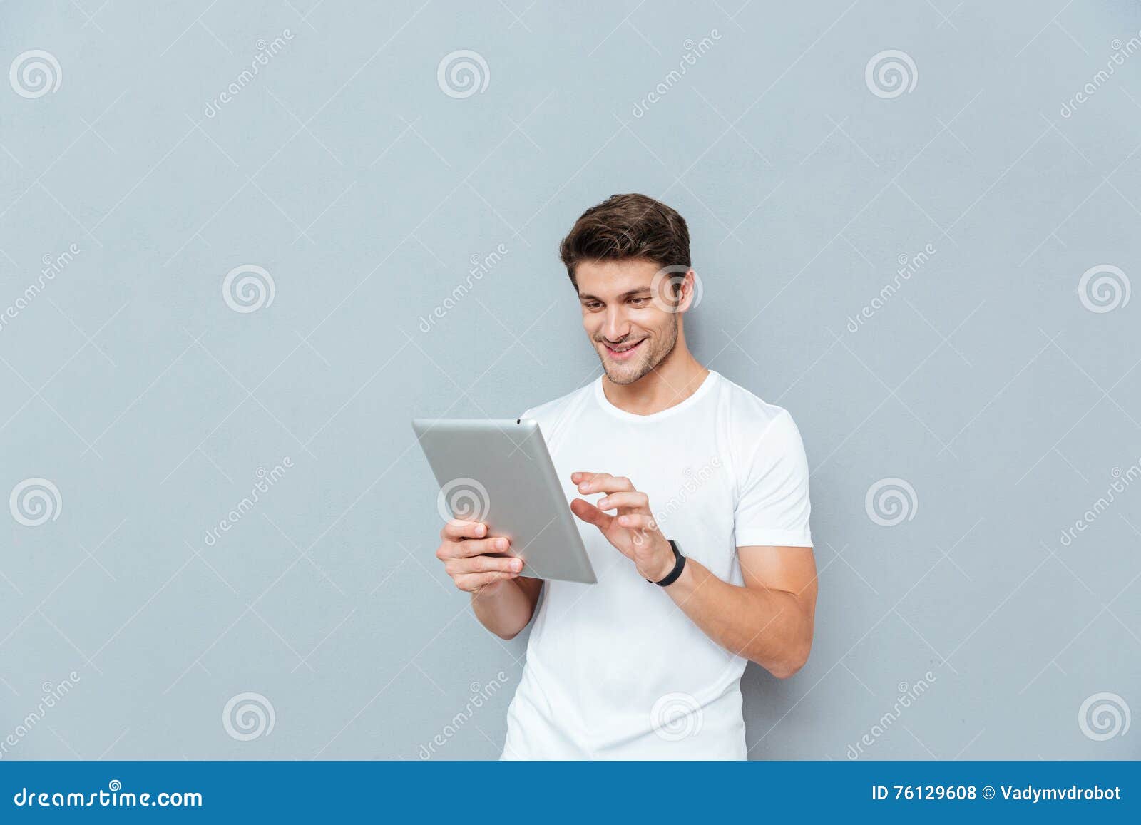 Happy Attractive Young Man Standing Using Tablet Over Grey Background ...