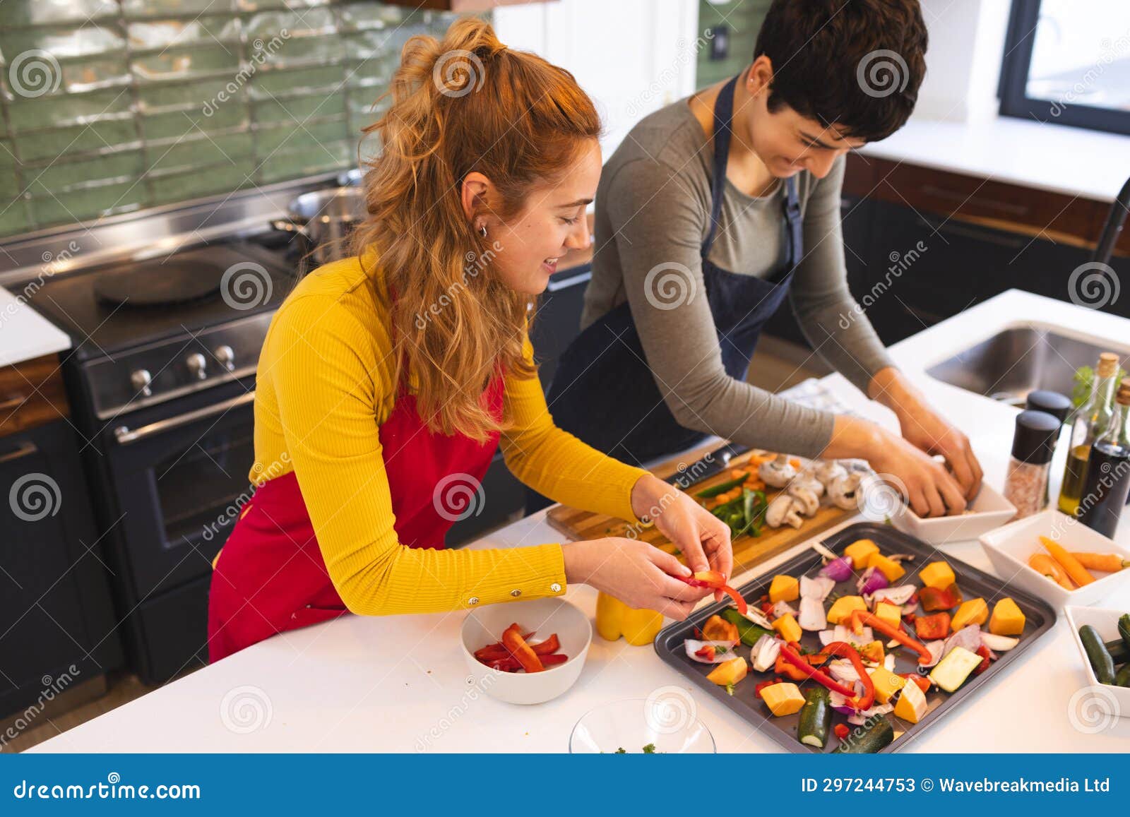 Happy Biracial Lesbian Couple Cooking Seasoning Chopped Vegetables In